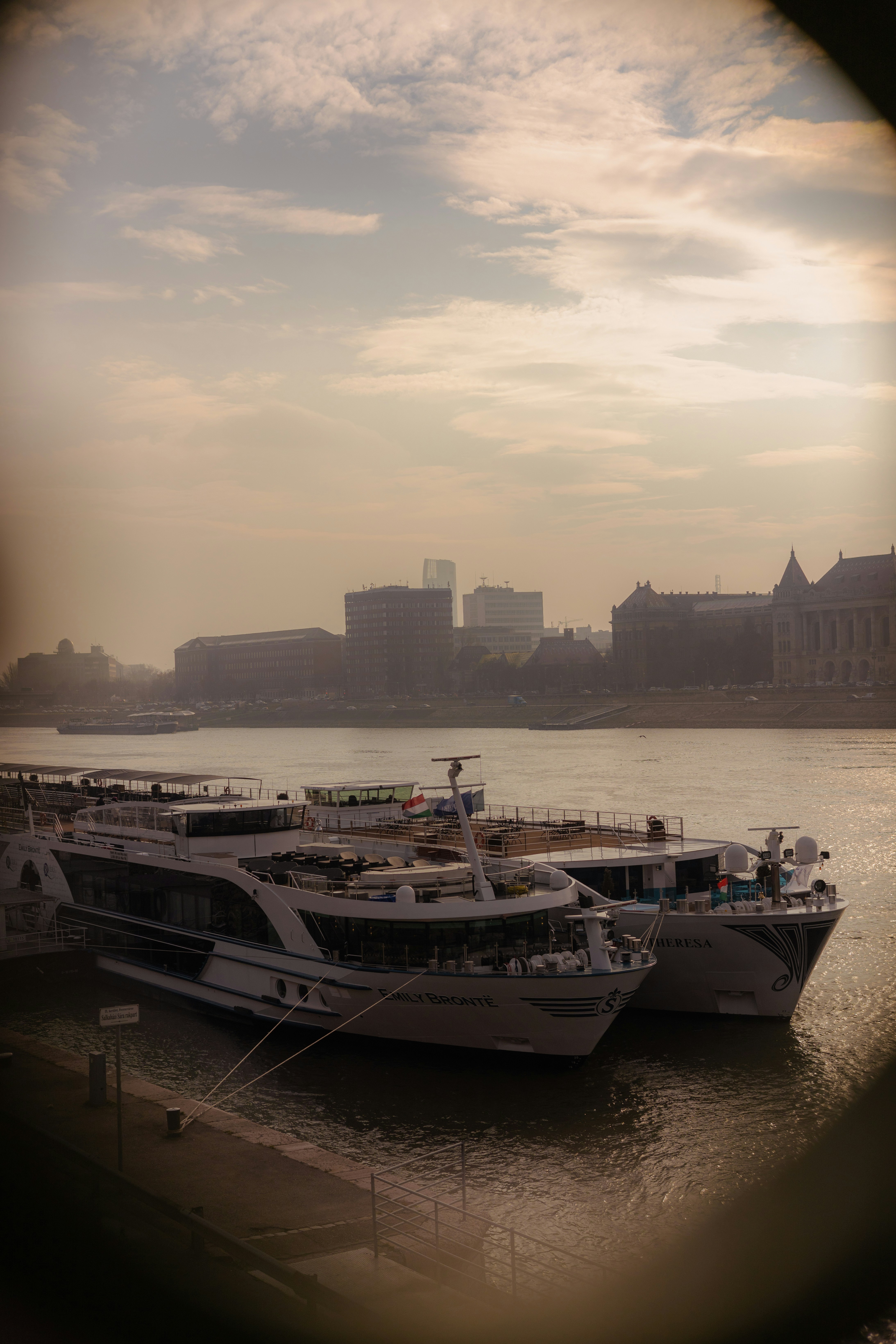 Golden Hour Harbor: Ferries and a Hazy City Silhouette