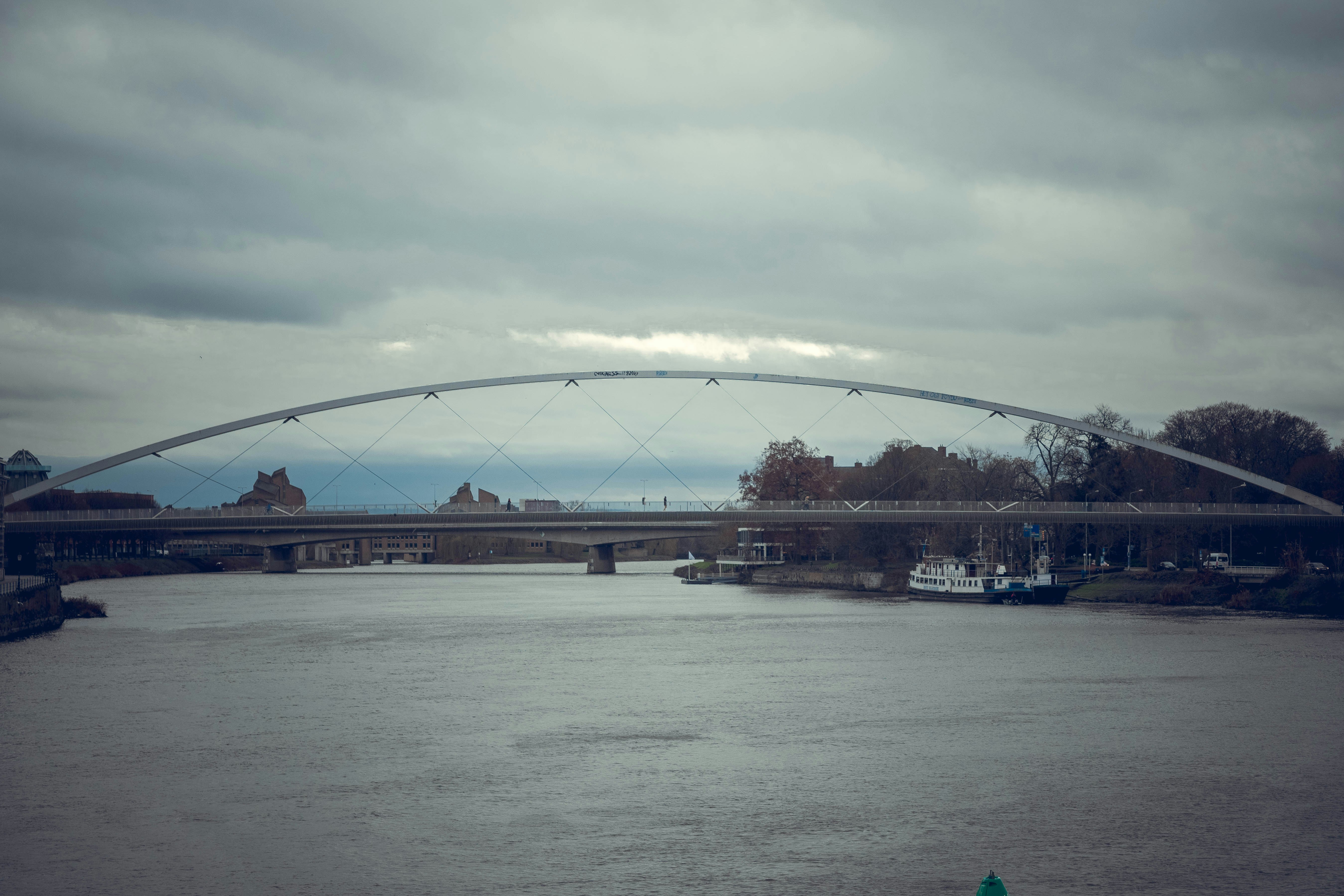 A bridge over a river with a green fire hydrant photo – Free ...