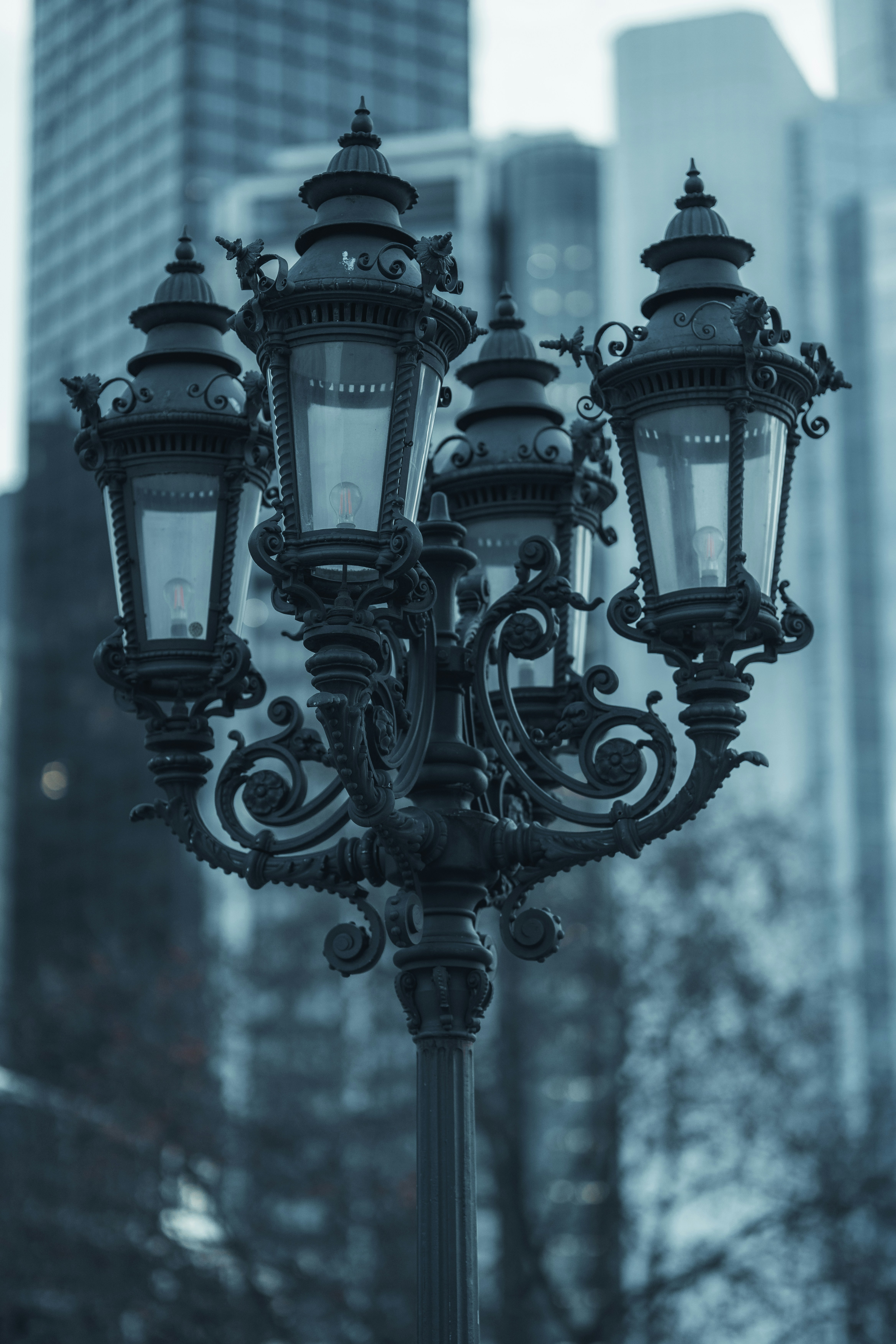 A lamp post in a city with tall buildings in the background photo ...