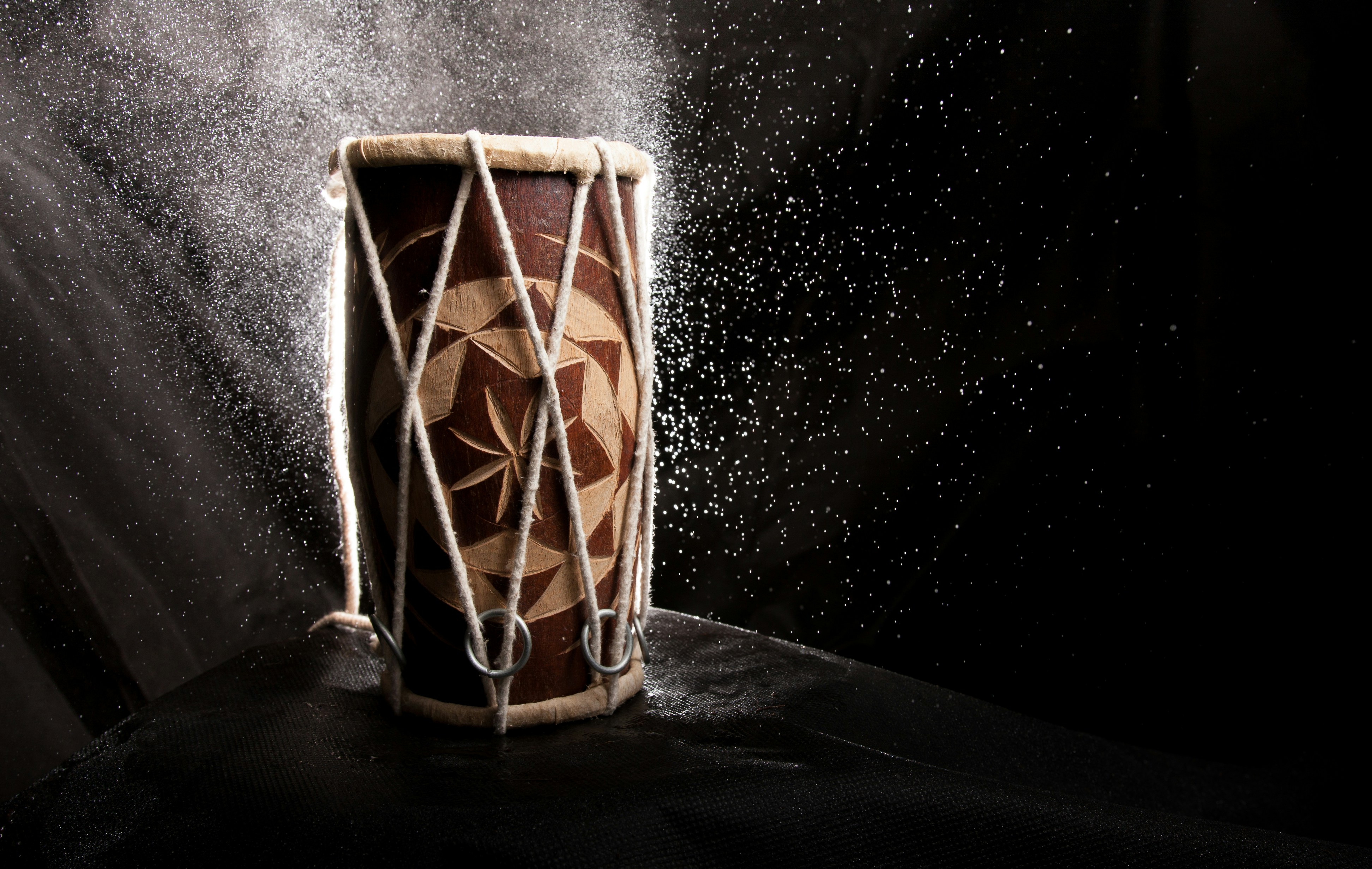 Un tambor con una cuerda alrededor sobre un fondo negro foto – Imagen ...