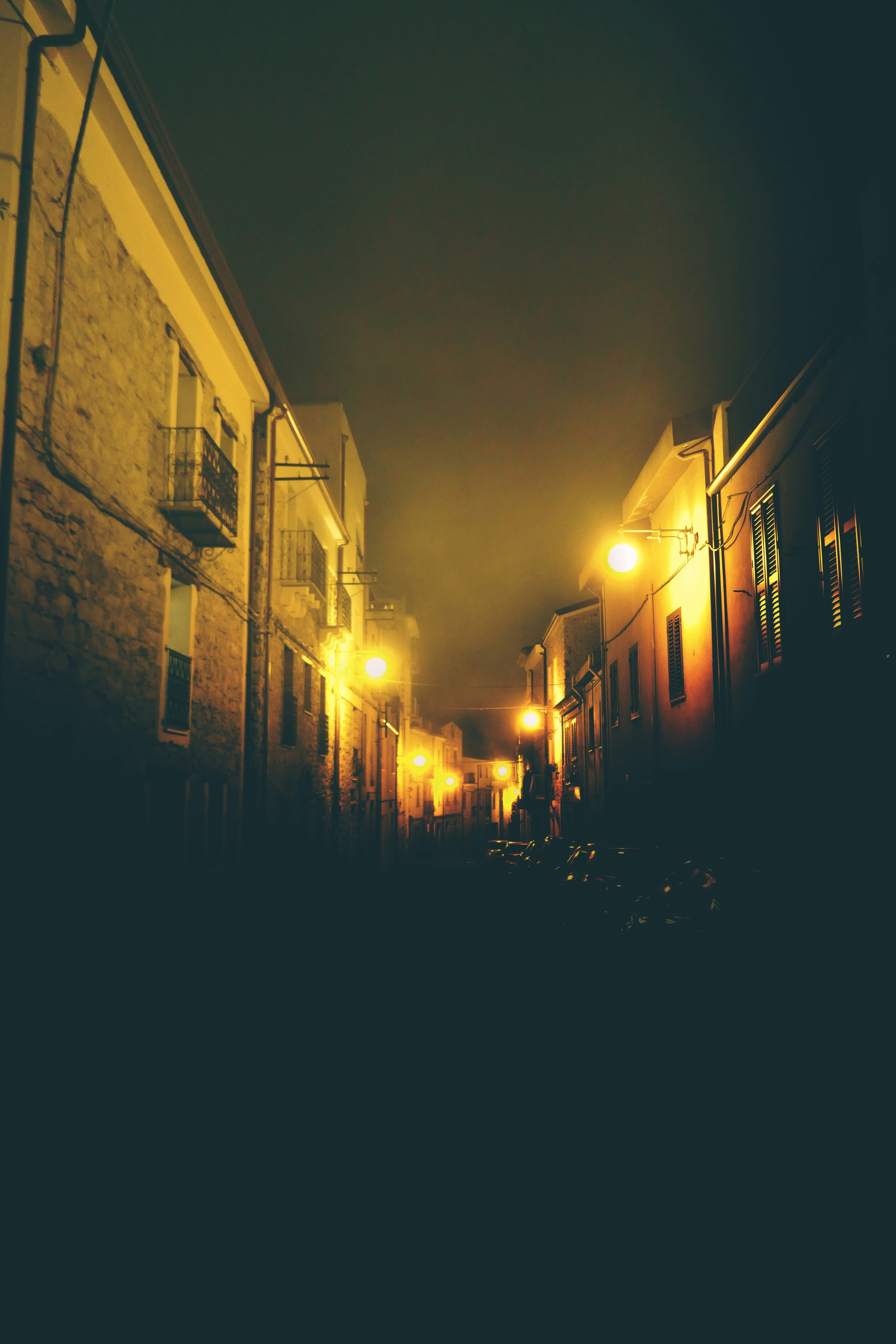 A city street at night with street lights photo – Free Neighborhood ...