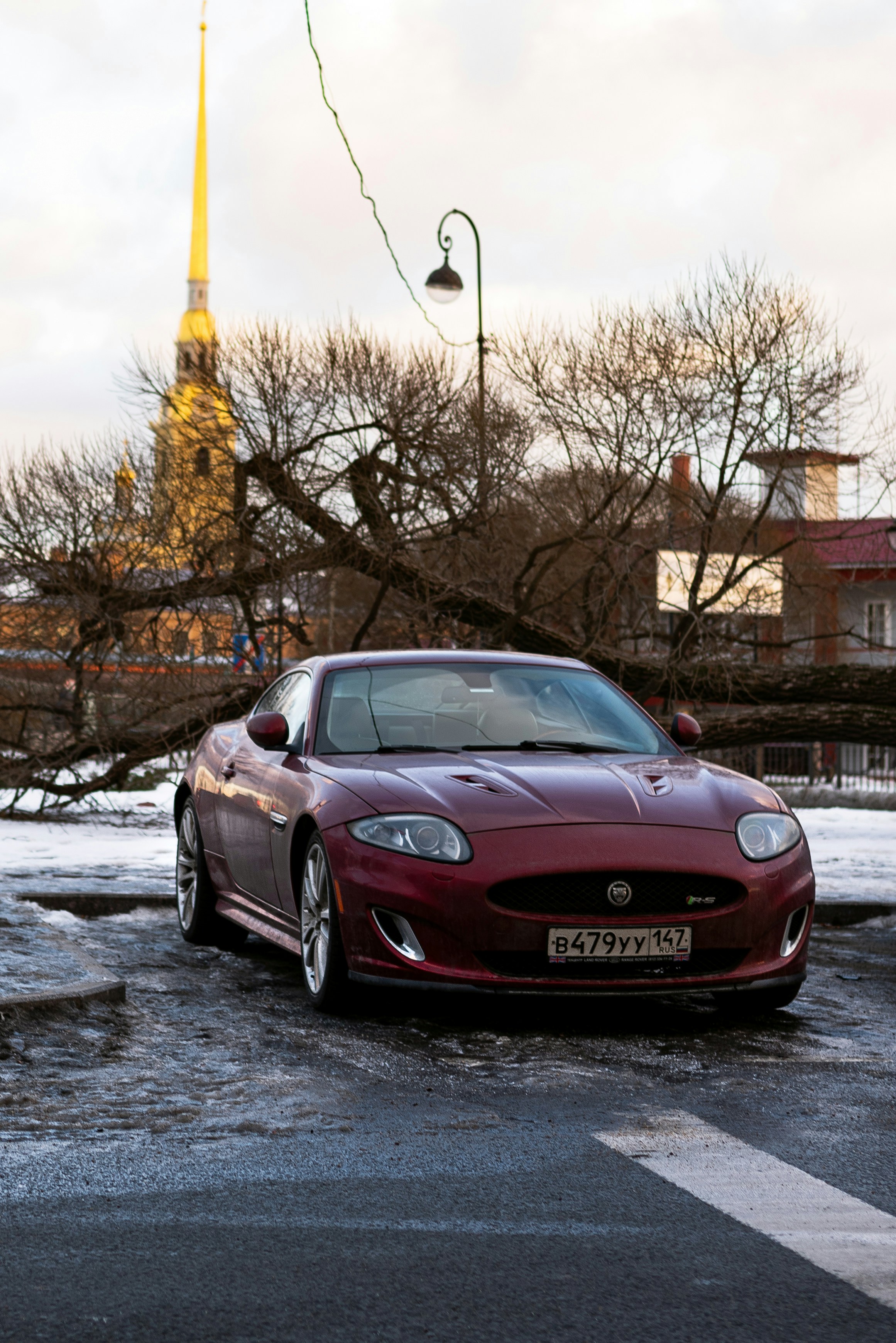 a maroon sports car parked in a parking lot