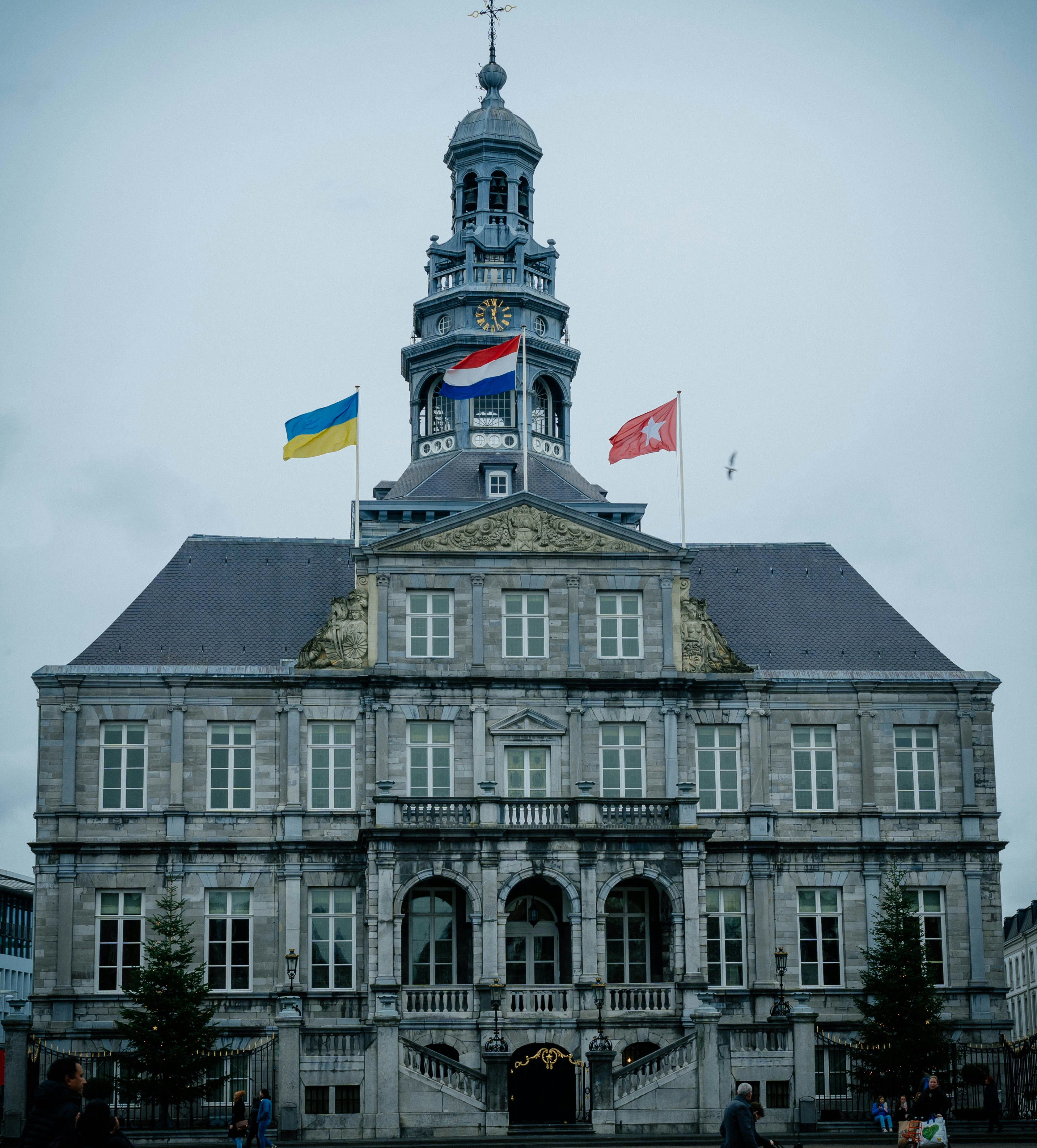 City Hall in Focus: Flags, Clock Tower, and Stone Facade