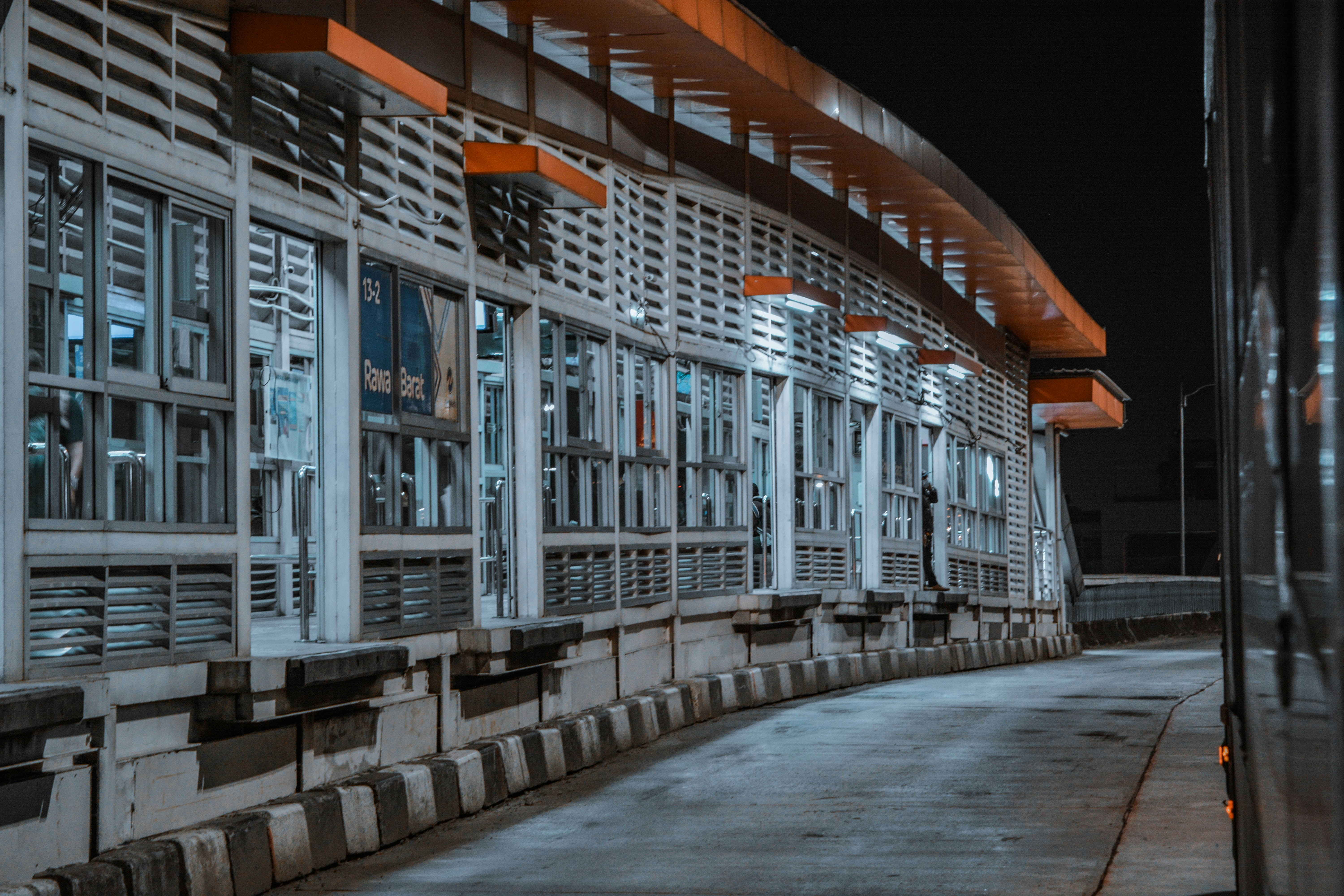 Echoes Along the Curved Platform: Neon Lines Under Orange Canopies