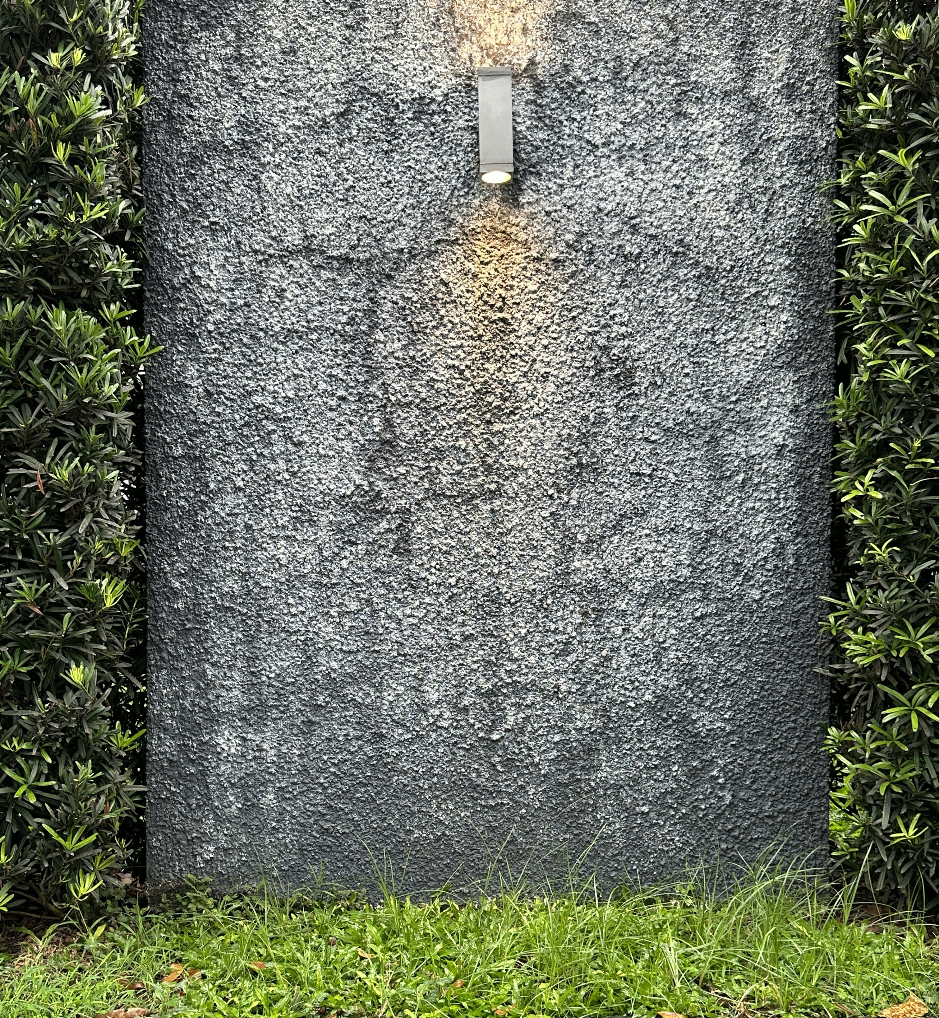 Lone Lantern on a Pebble-Grained Wall