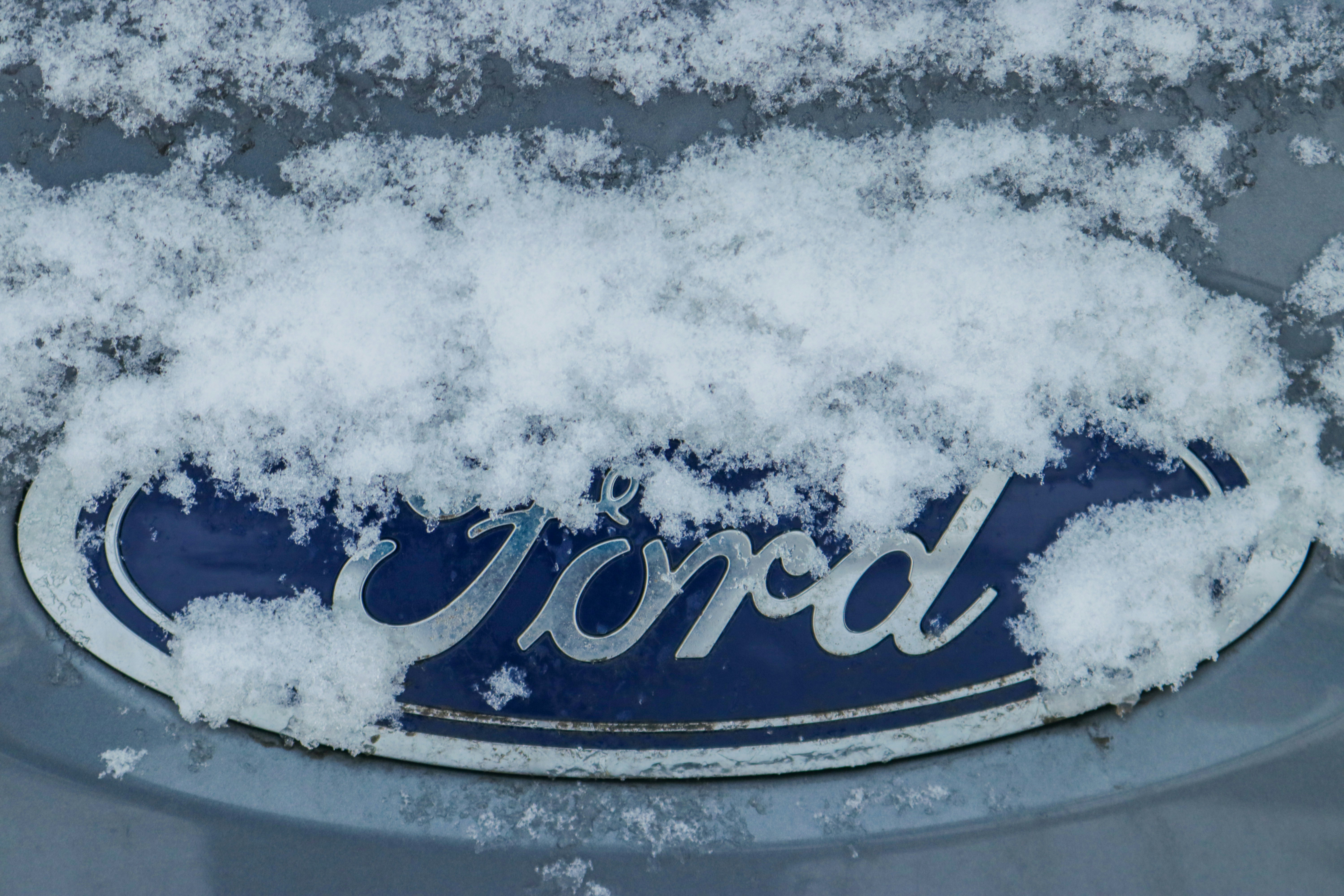 A close up of a snow covered ford emblem photo – Free Image on Unsplash