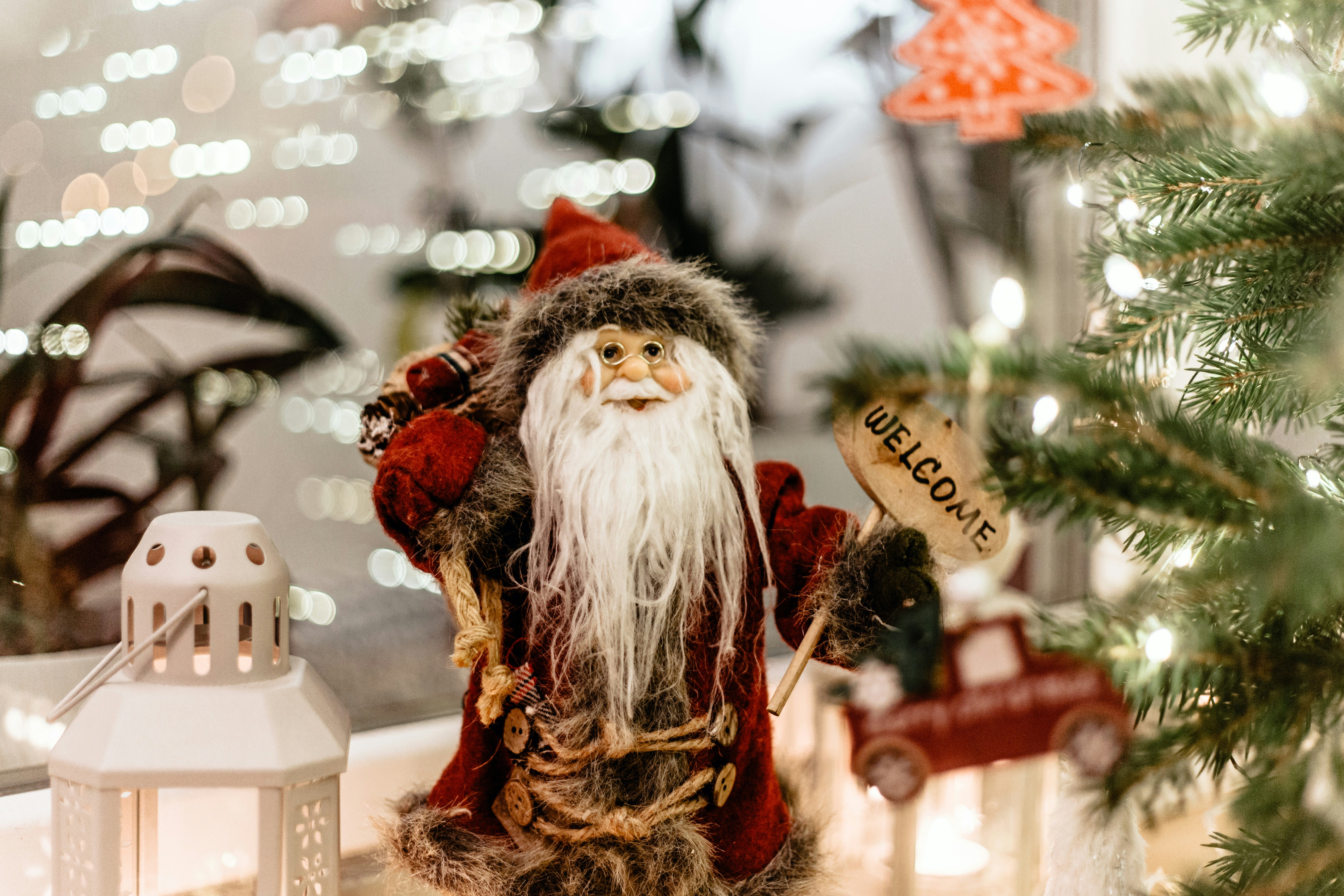 A santa clause figurine next to a christmas tree photo – Free Christmas ...