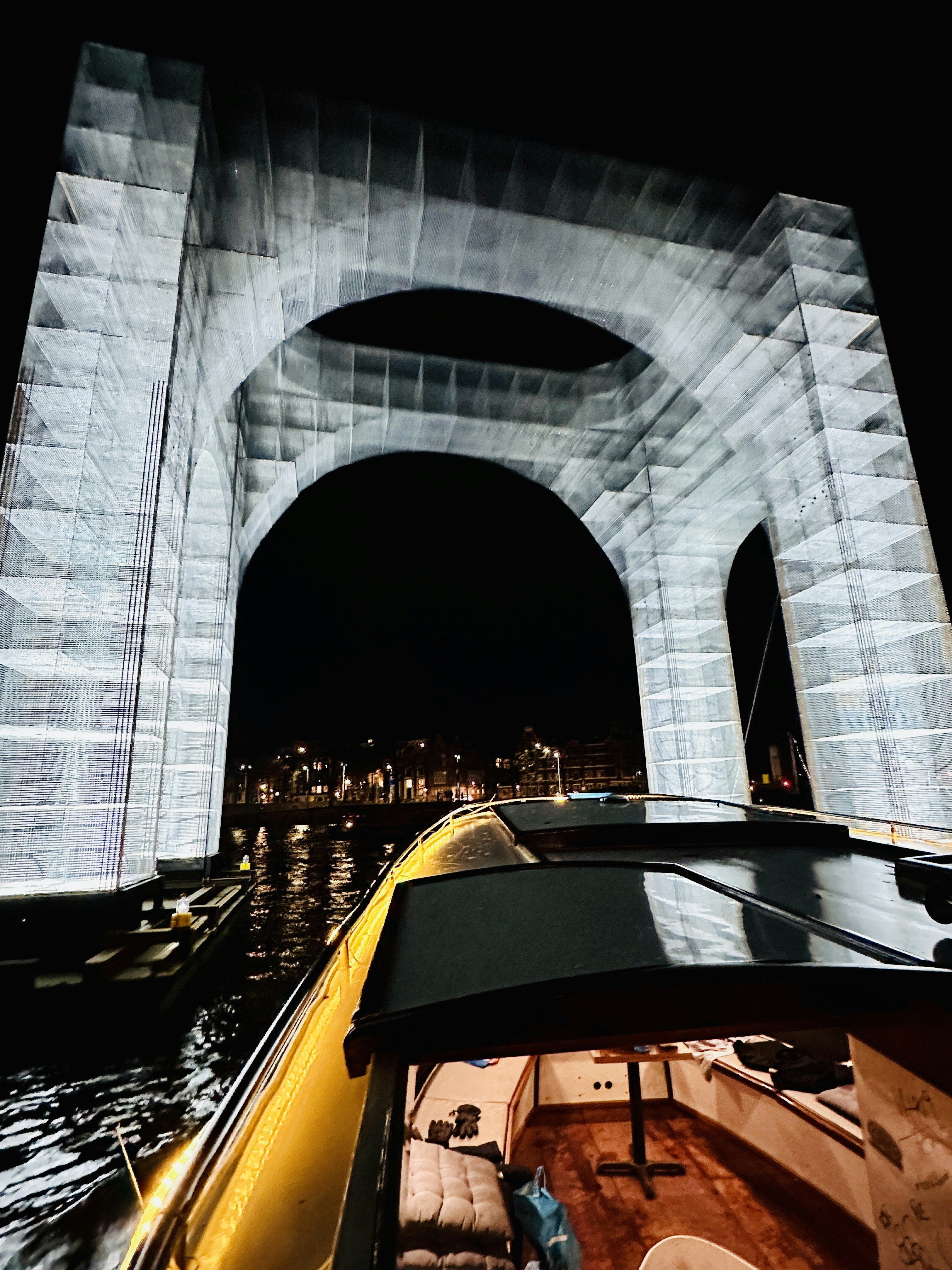 A boat traveling under a bridge at night photo – Free Amsterdam Image ...