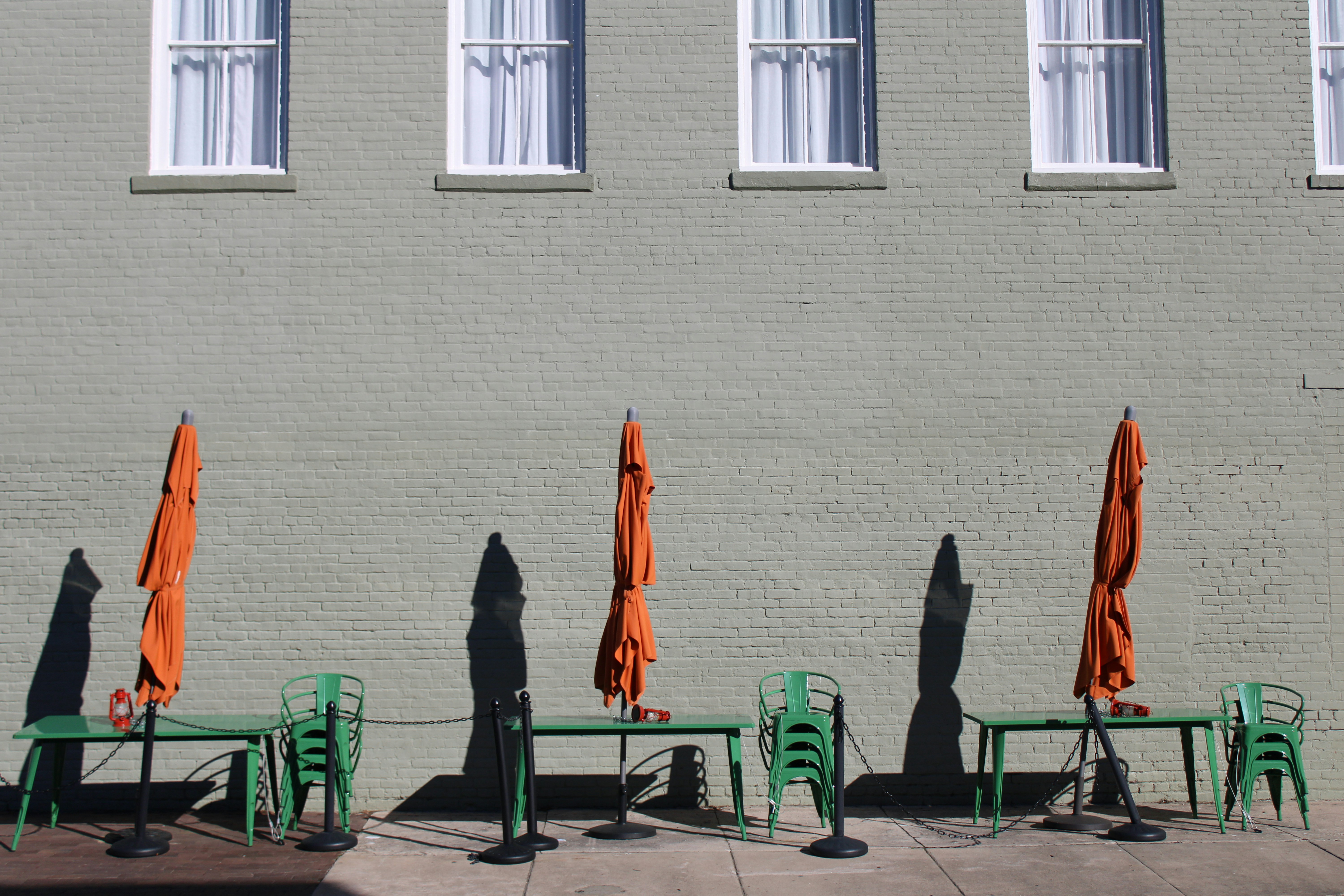 a group of tables and chairs with orange umbrellas