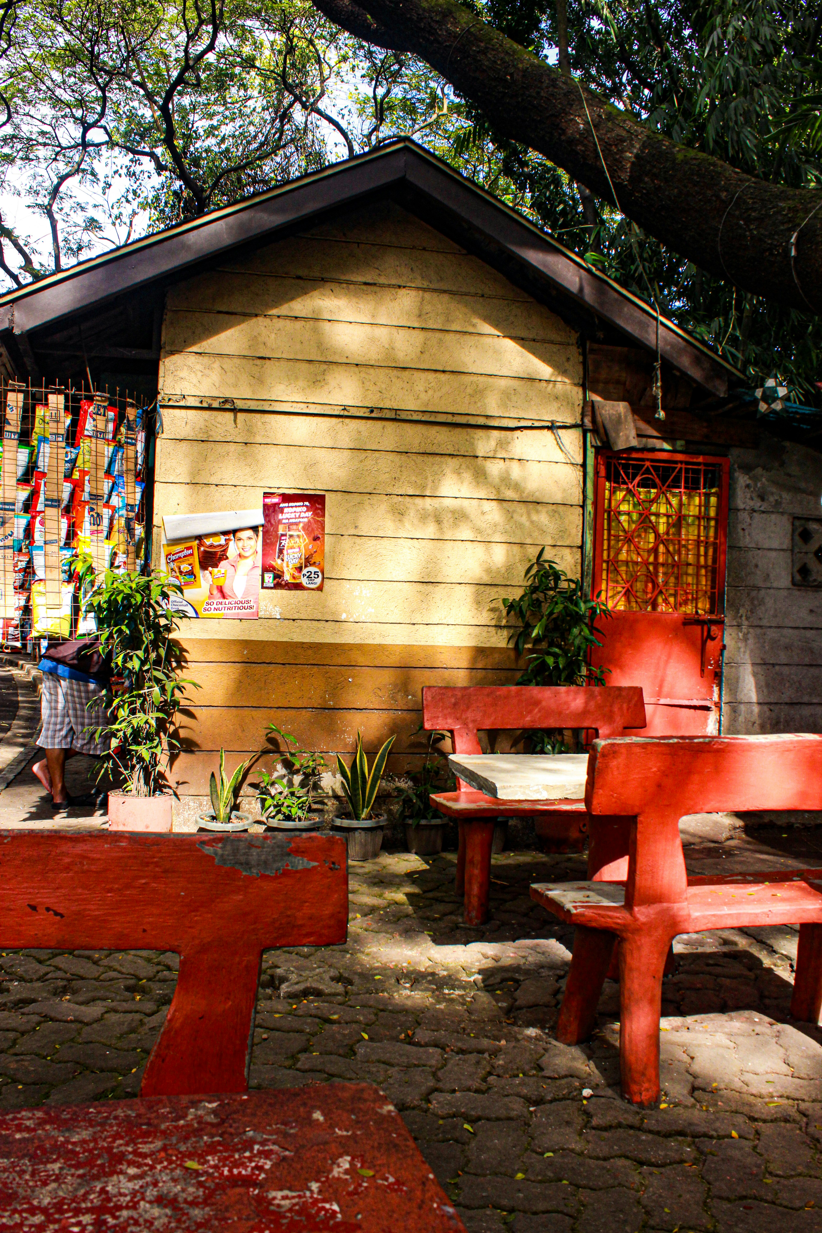 A couple of red benches sitting in front of a building photo – Free ...