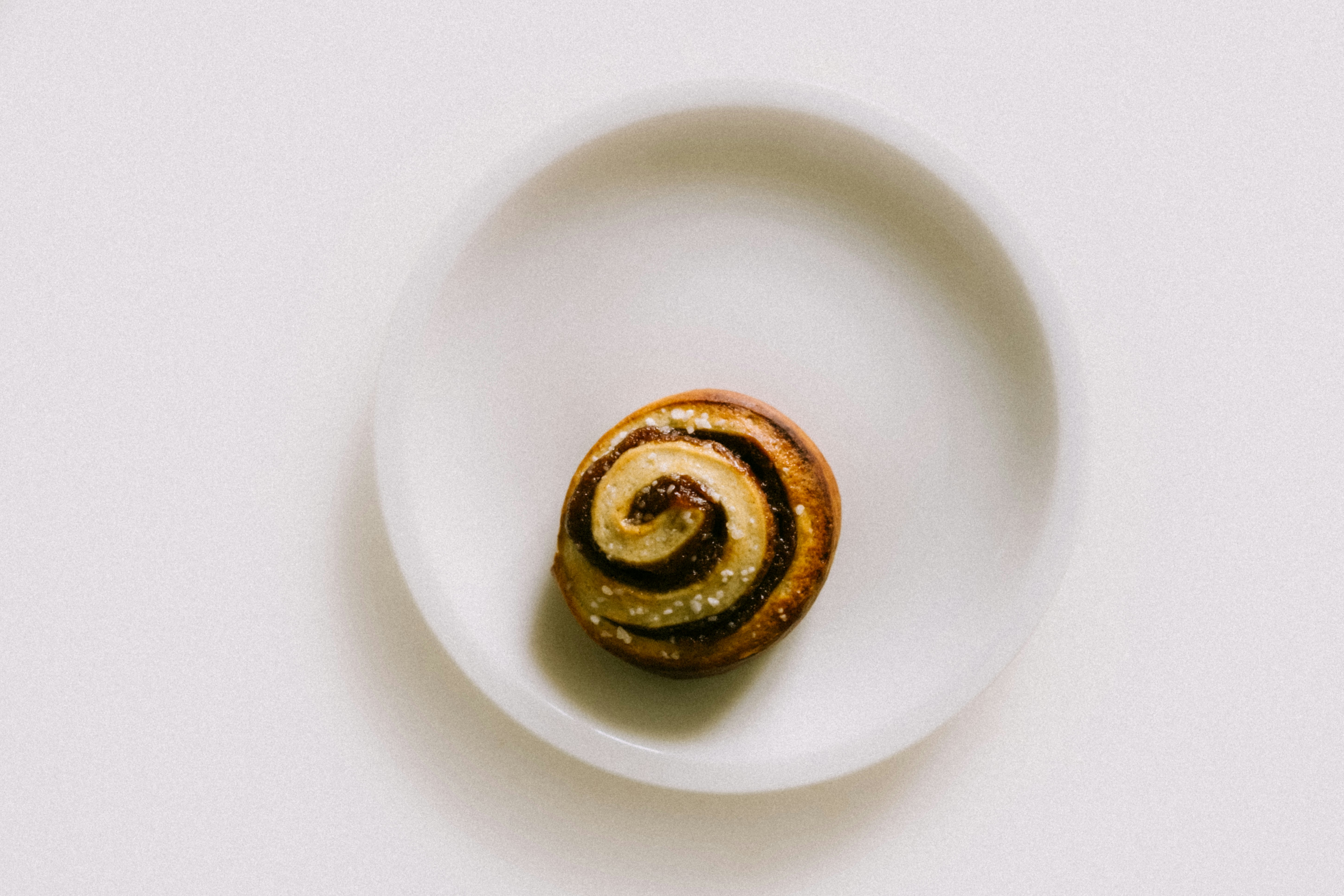 Minimalist Cinnamon Spiral on a Quiet White Plate