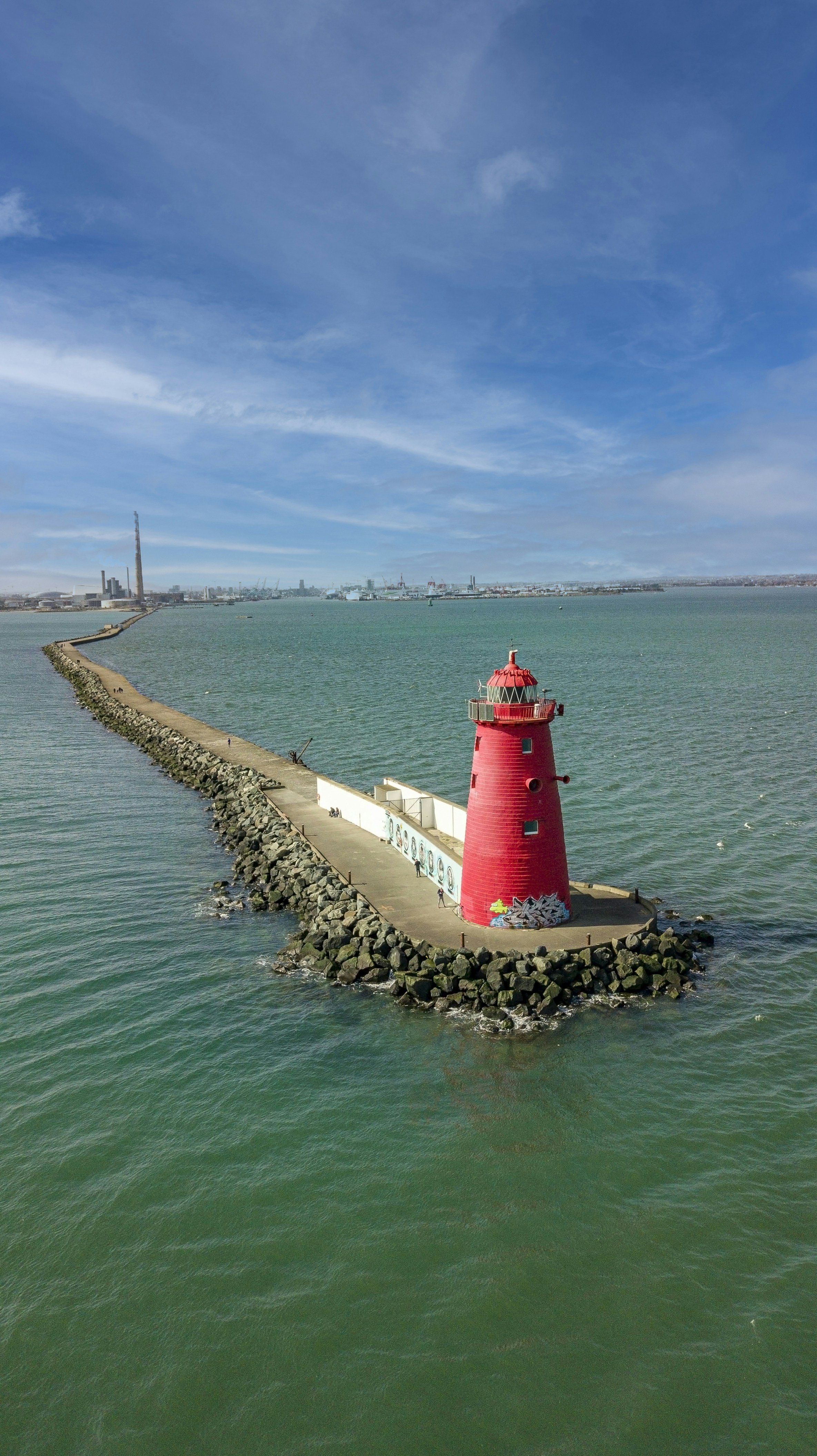 Red Beacon at the Breakwater: A Lone Lighthouse Pointing Toward the Sea