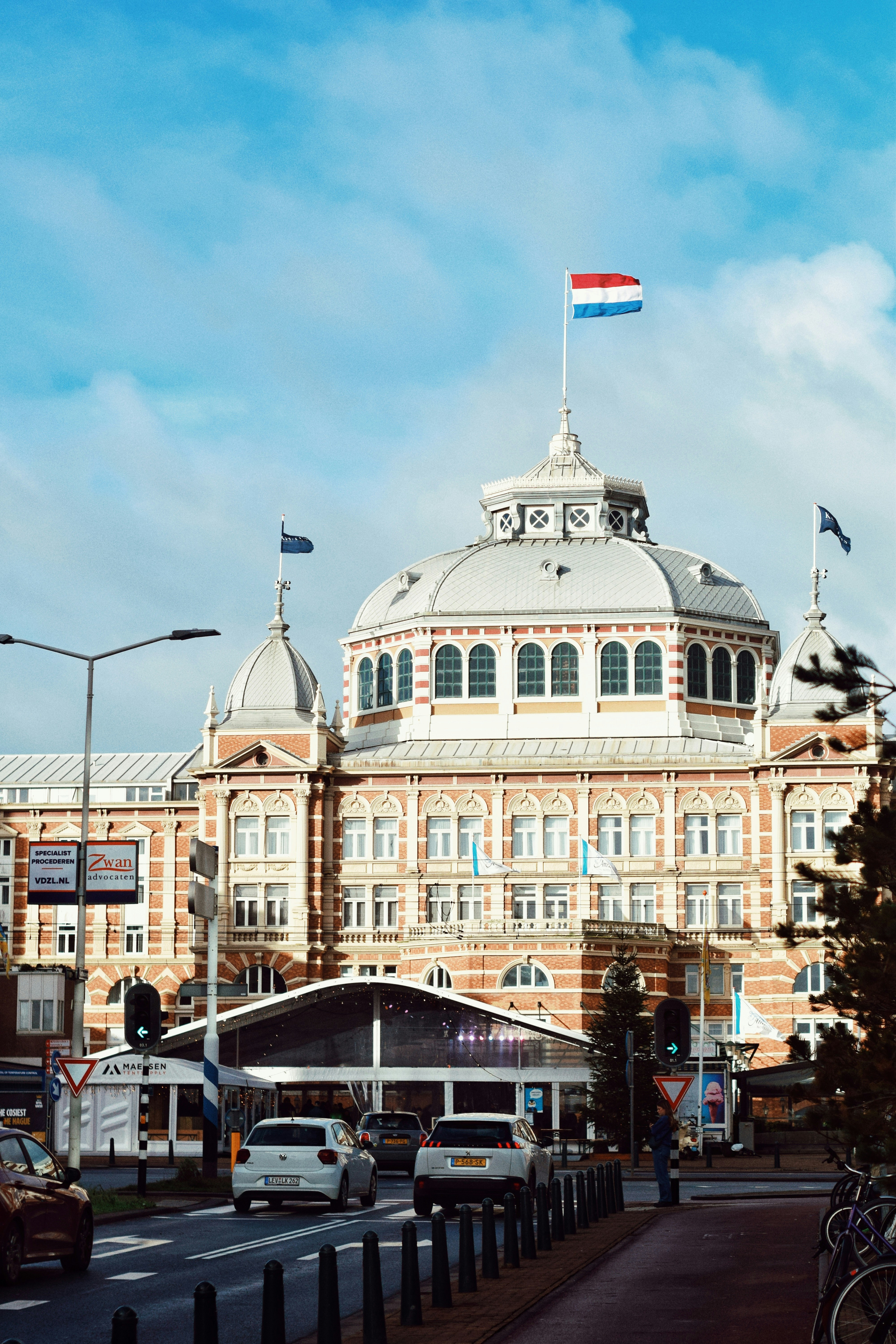 Flag at the Dome: Sunlit Brick City Hall Under a Clear Blue Sky