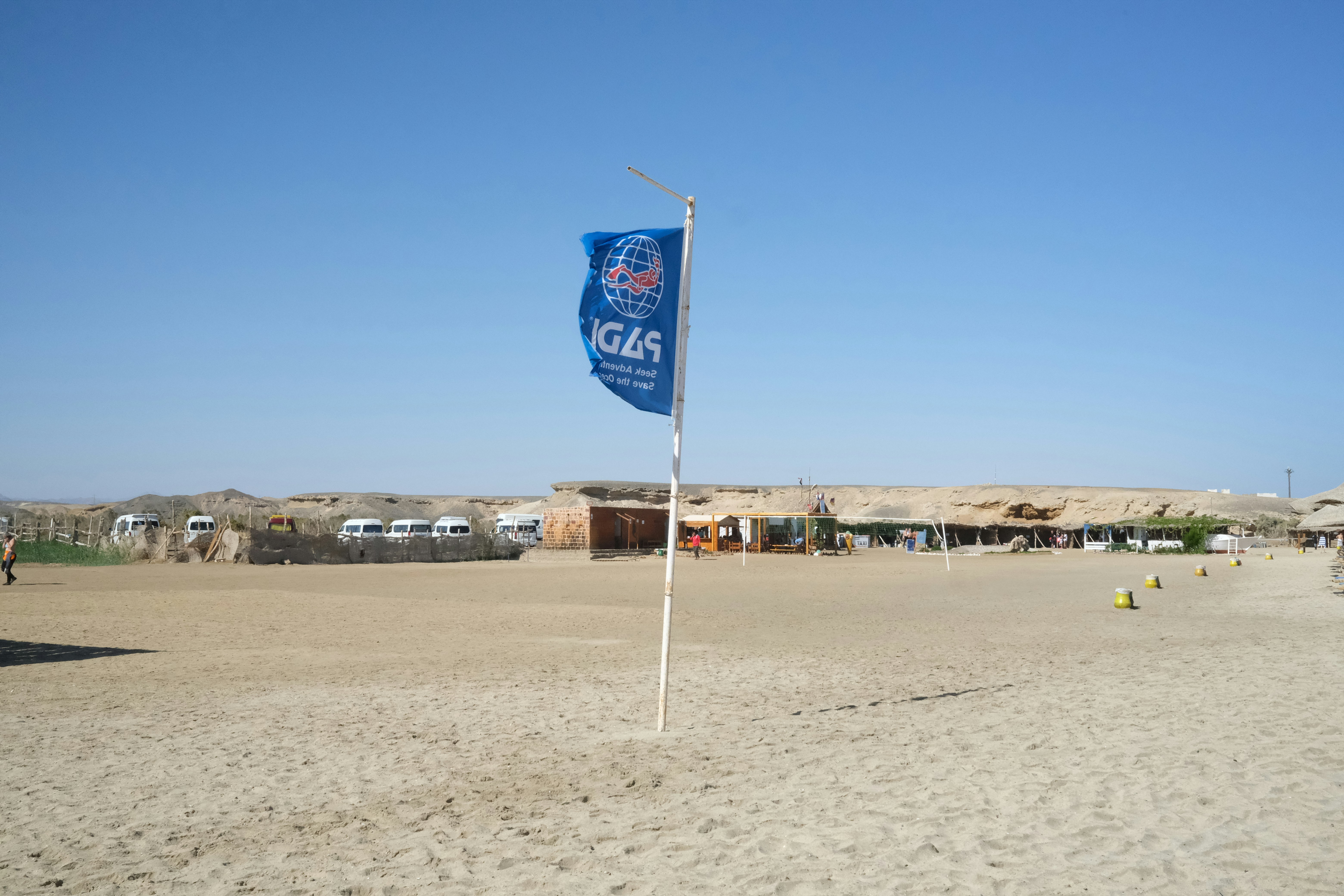 A flag on a pole in the middle of a sandy area photo – Free Marsa alam ...