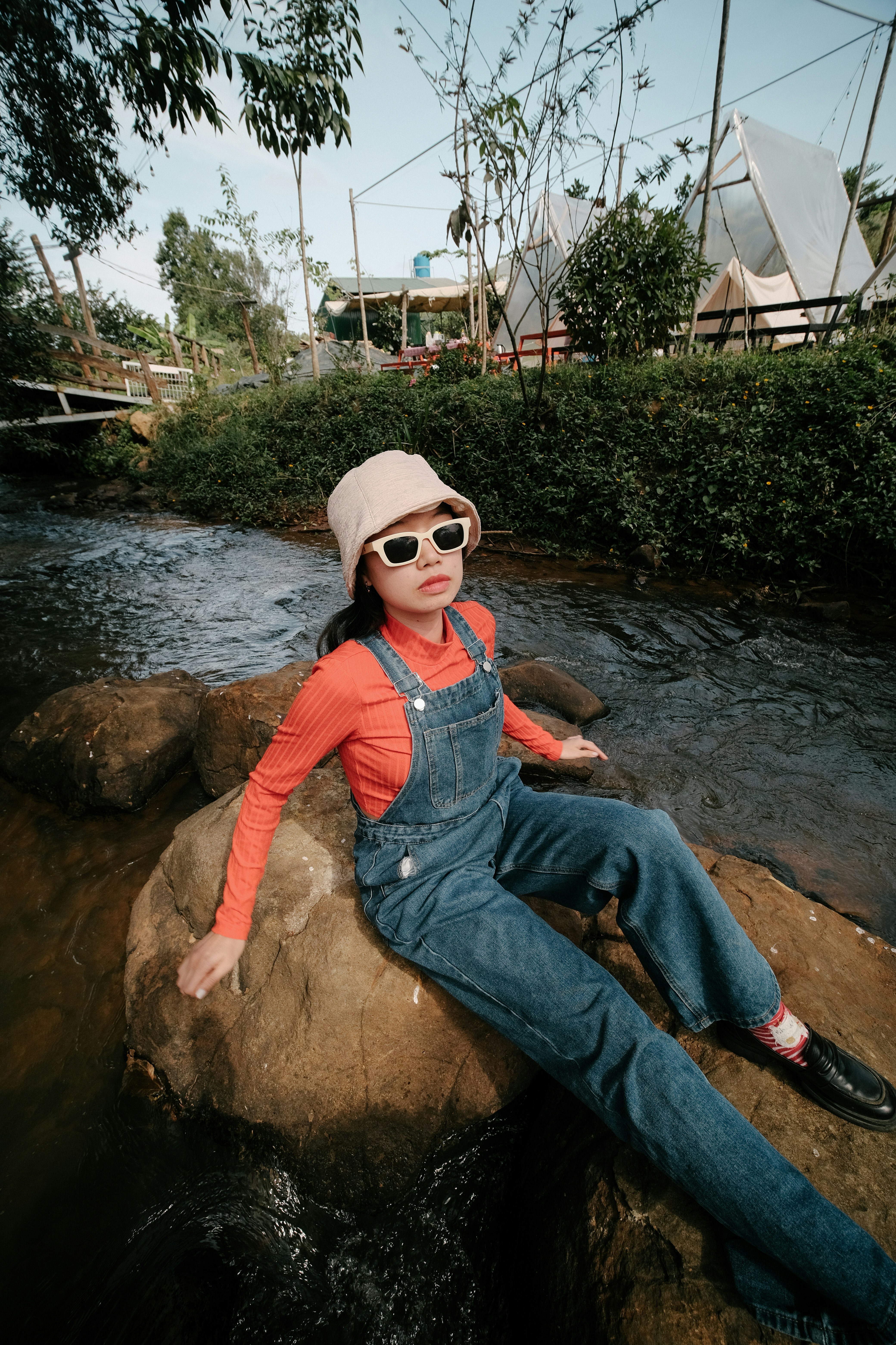 Denim Explorer by the River: A Quiet Portrait on Worn Rocks