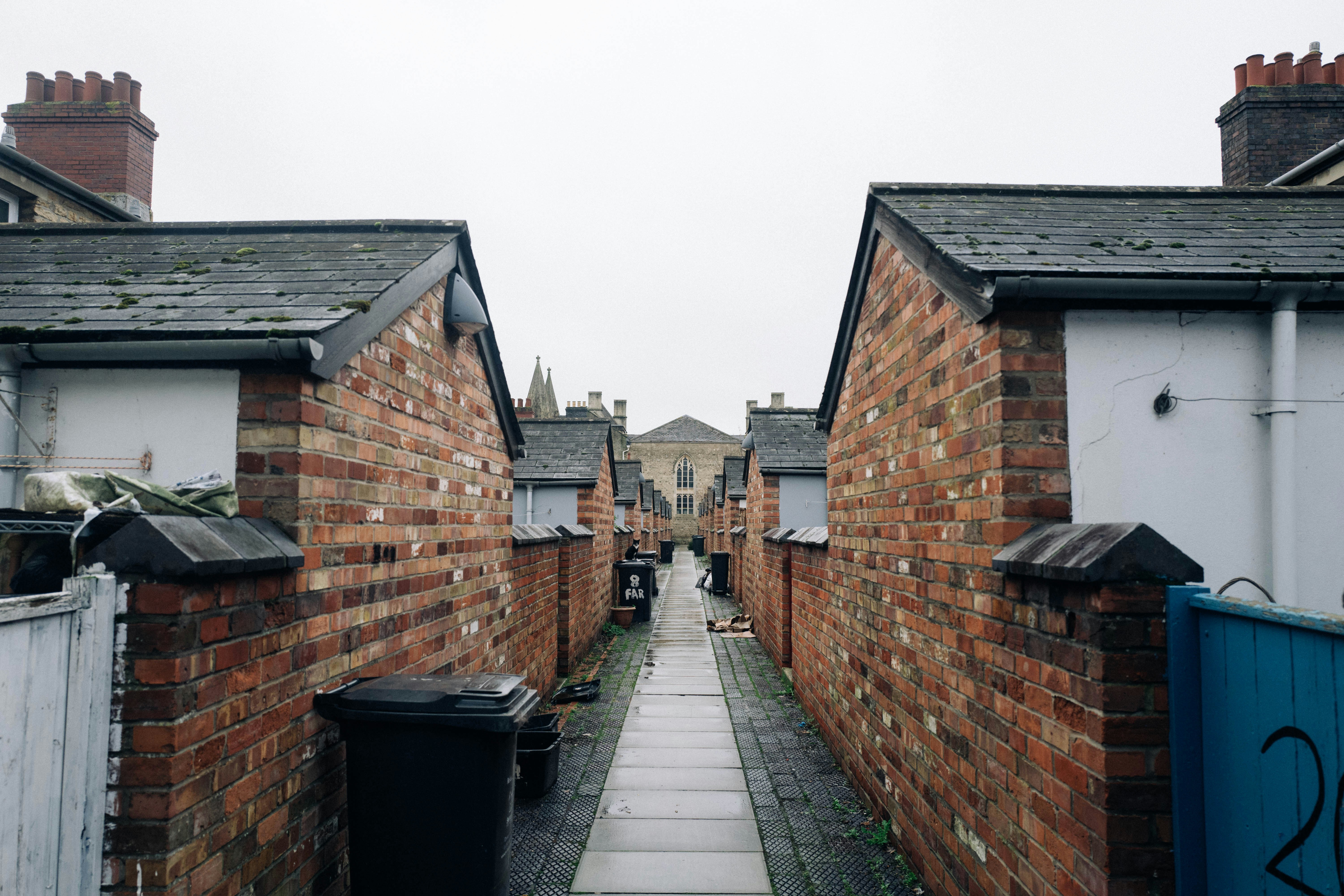 A narrow alley way between two brick buildings photo – Free Archicture ...