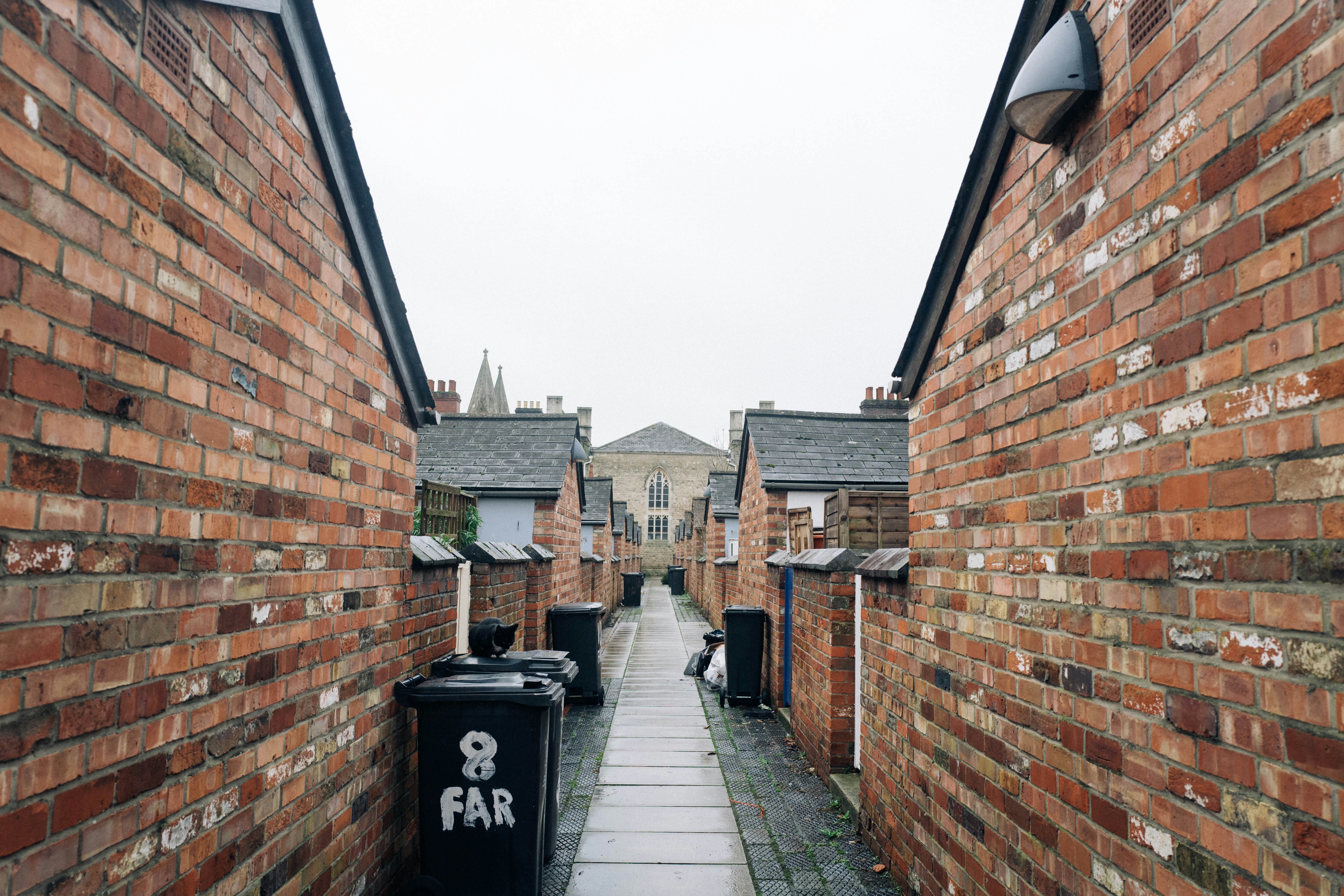 A narrow alley way between two brick buildings photo – Free Archicture ...