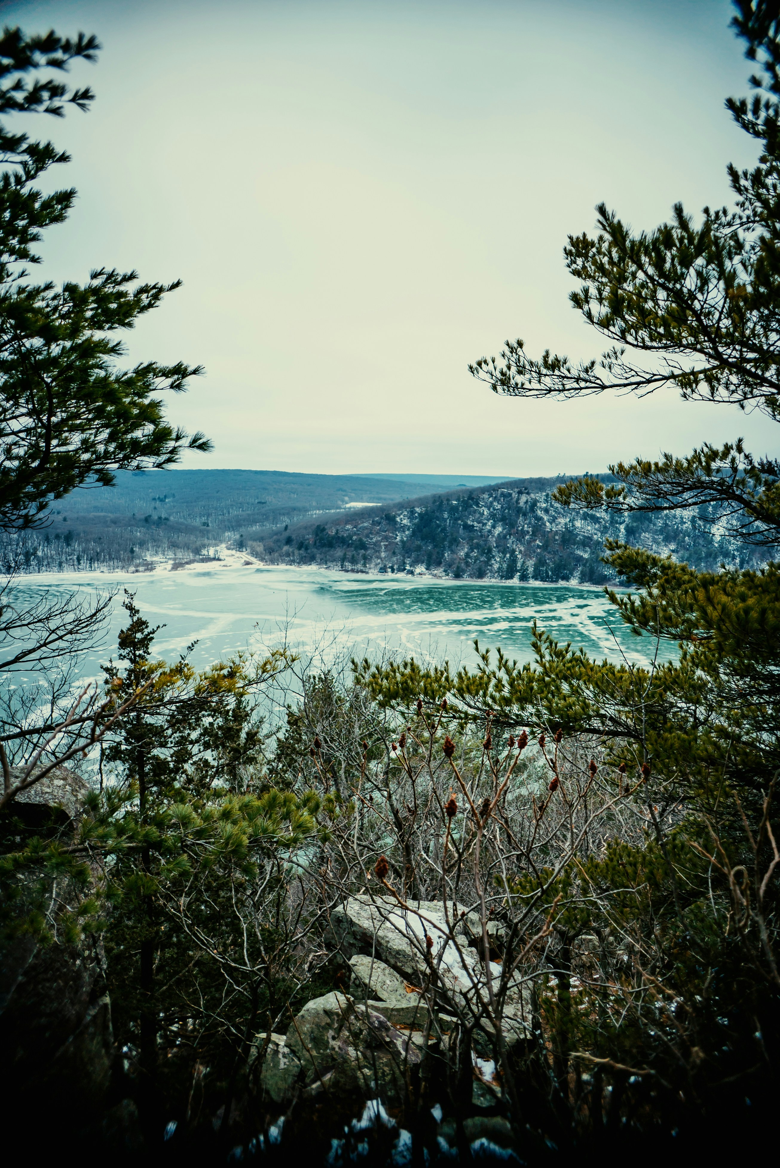 Winter Rim: Pines Framing a Frozen Lake from a Cliff Edge