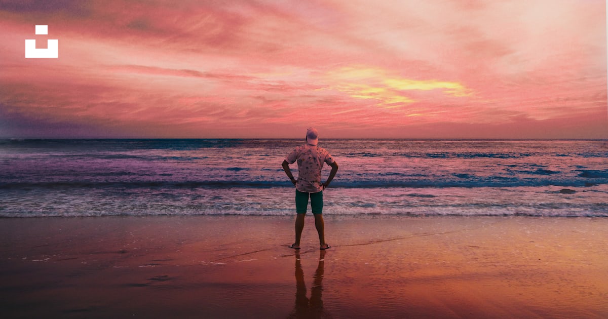 Un Hombre Parado En La Cima De Una Playa Junto Al Océano Foto Imagen
