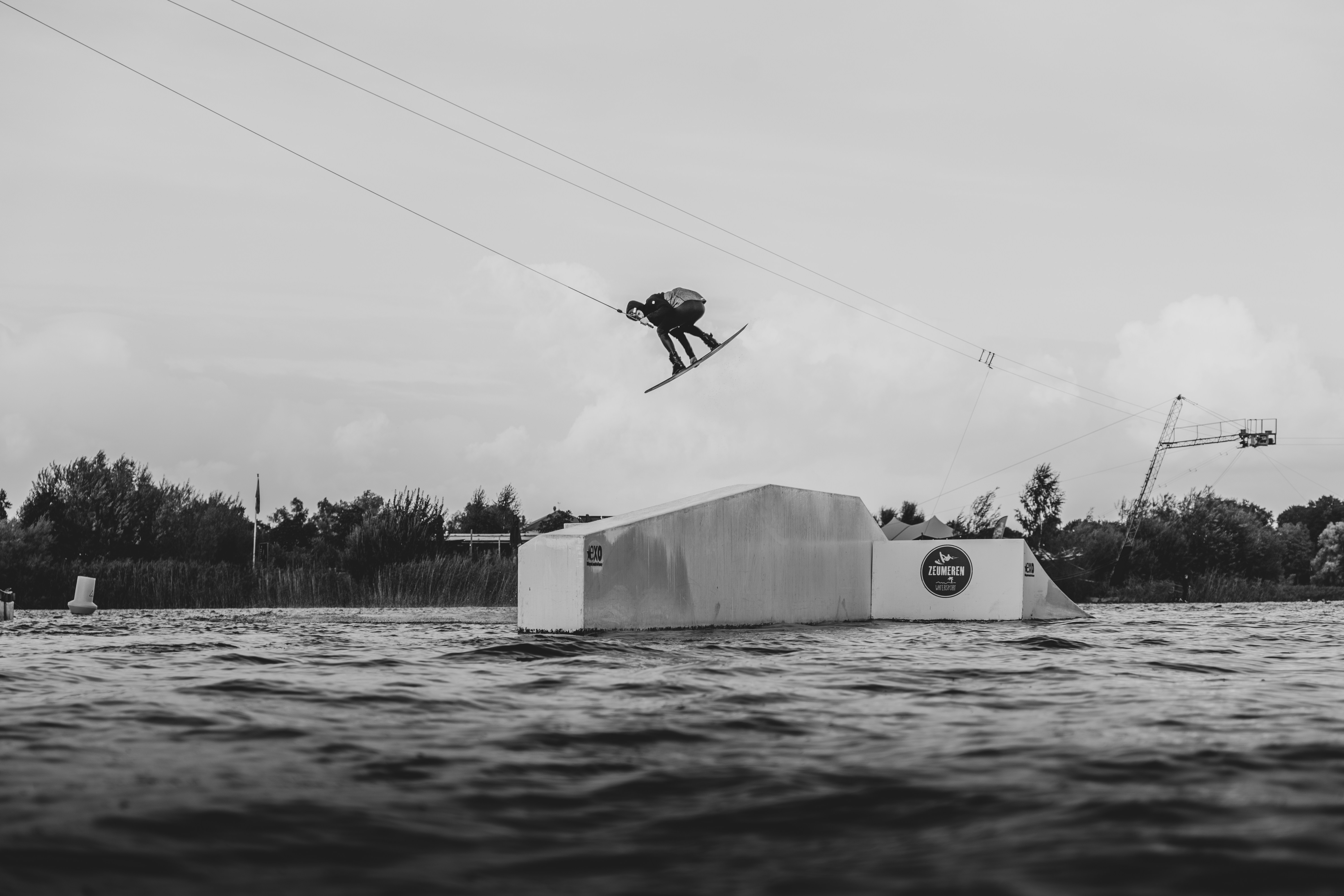 Midair Kickflip: Snowboarder Skims a Cable Wake