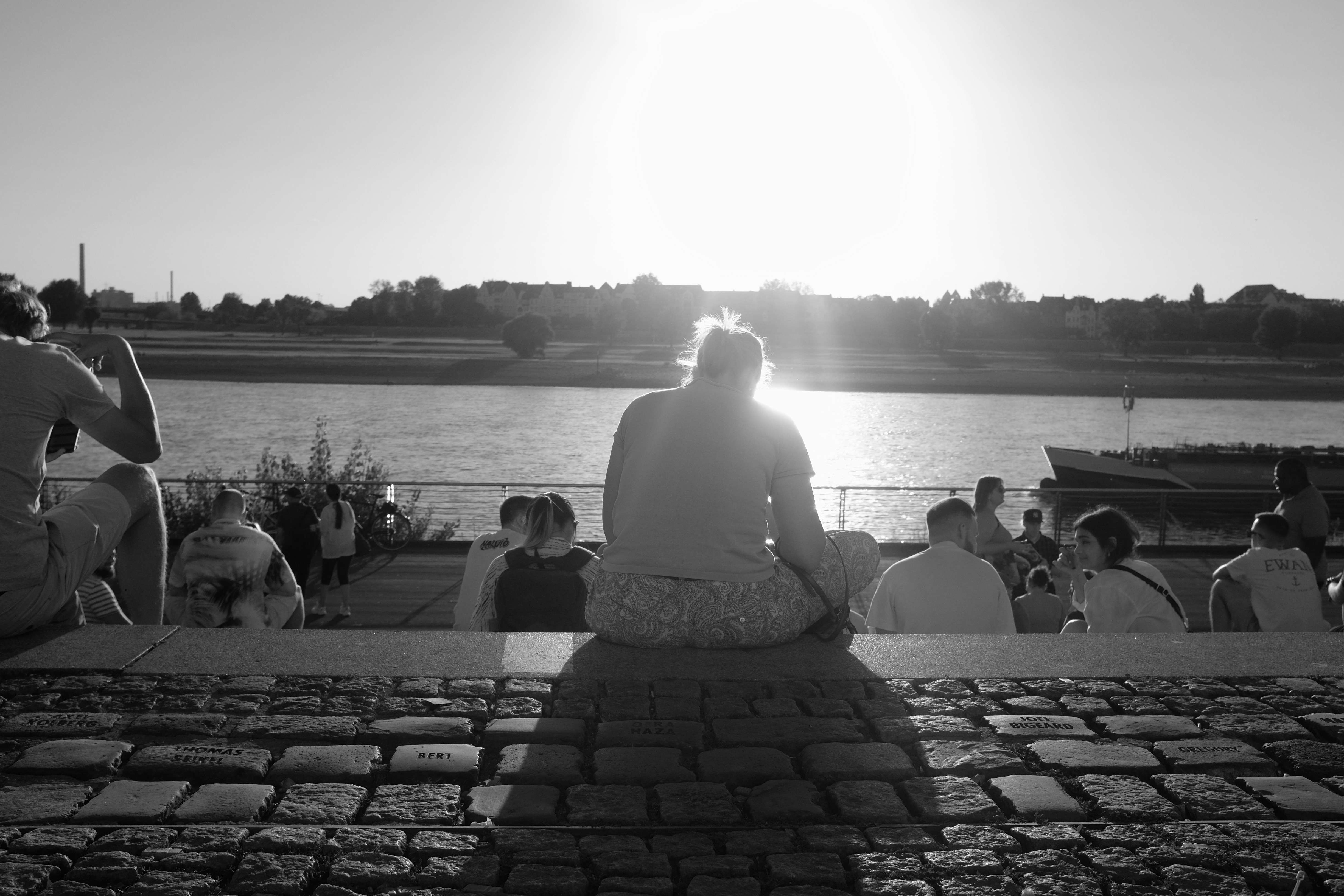 Silhouette by the River: Evening Glow on the Stone Terrace