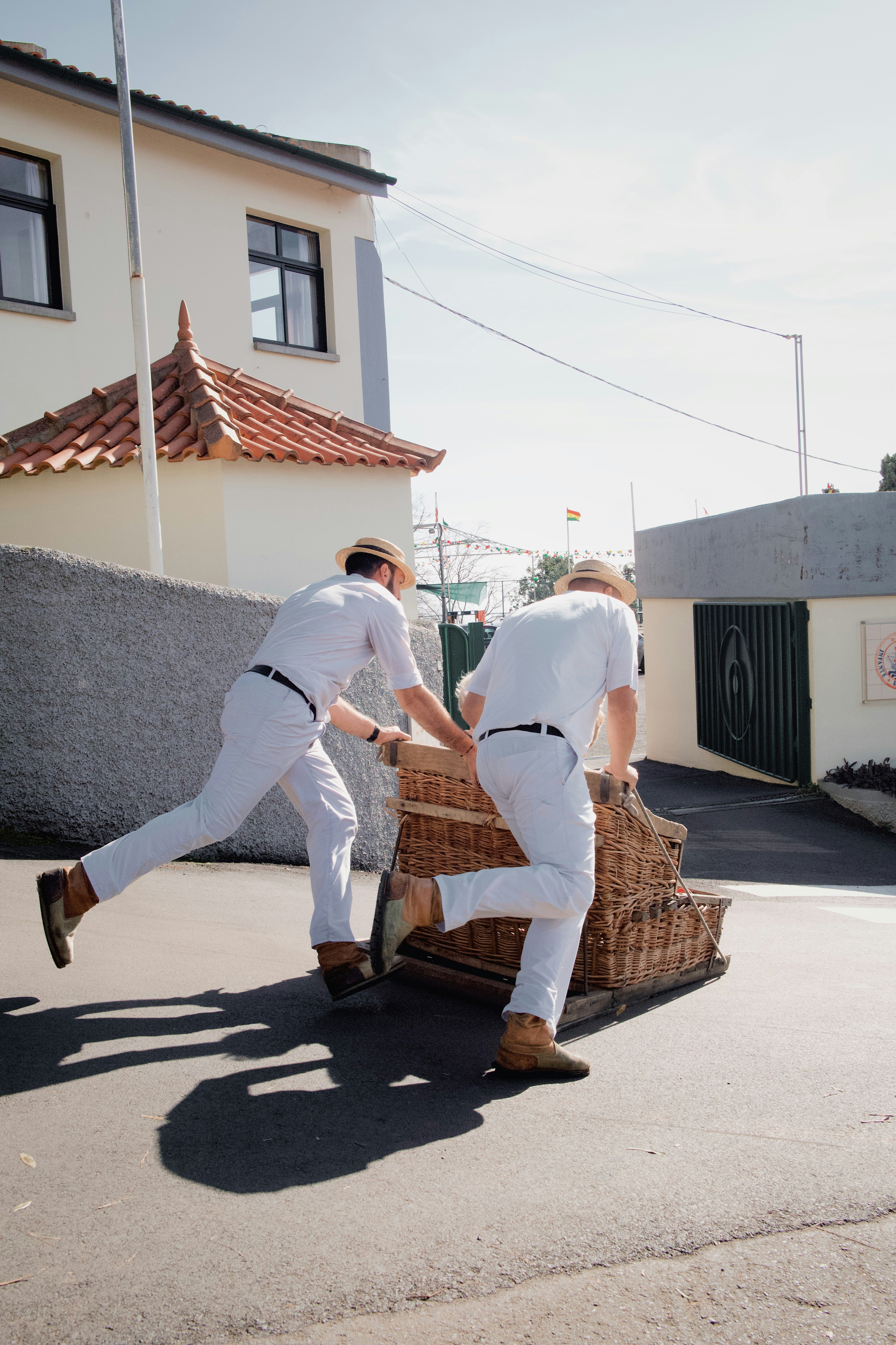 Two men in white suits pushing a basket photo – Free Pushing Image on ...