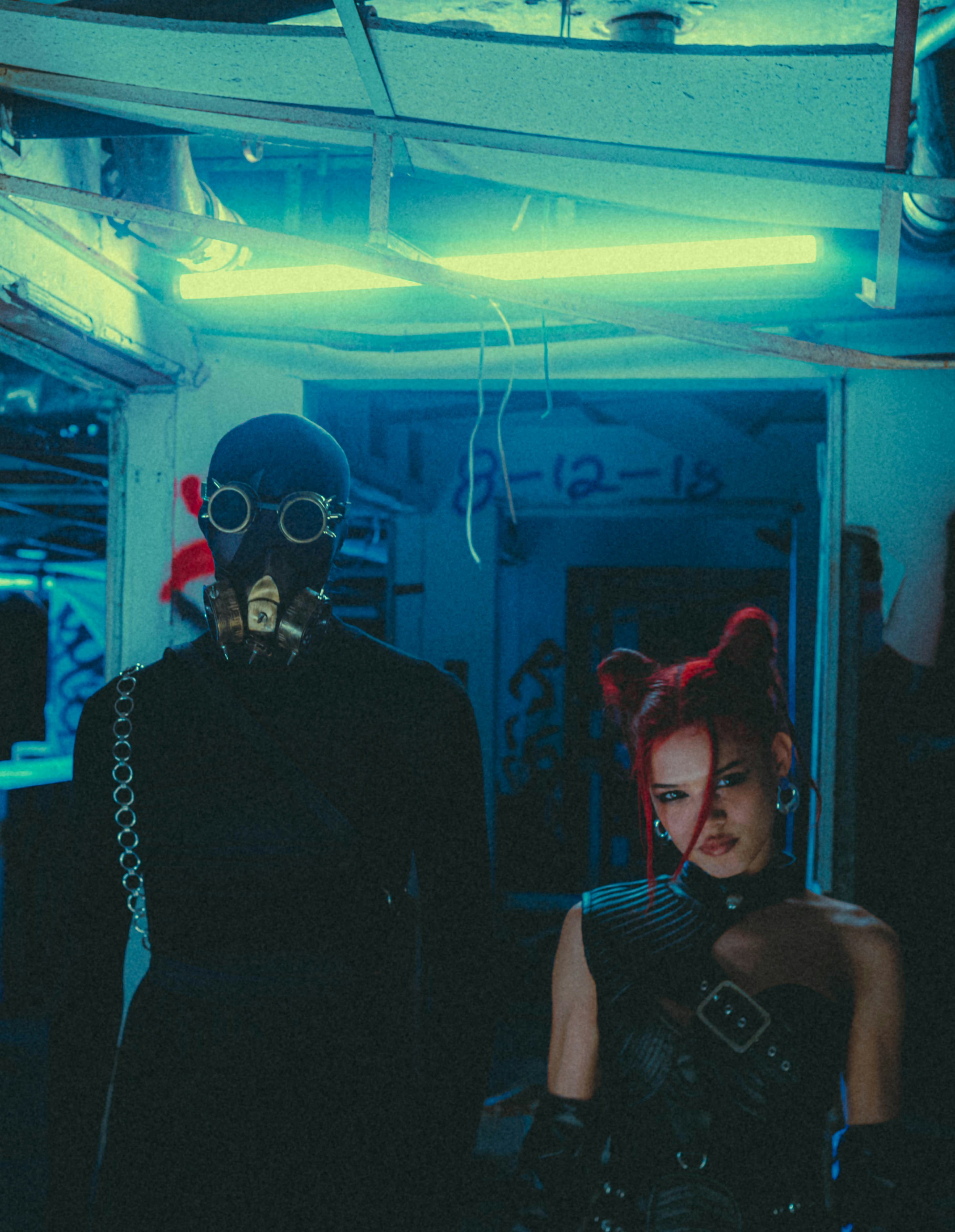 Gothic duo in neon-lit shelter