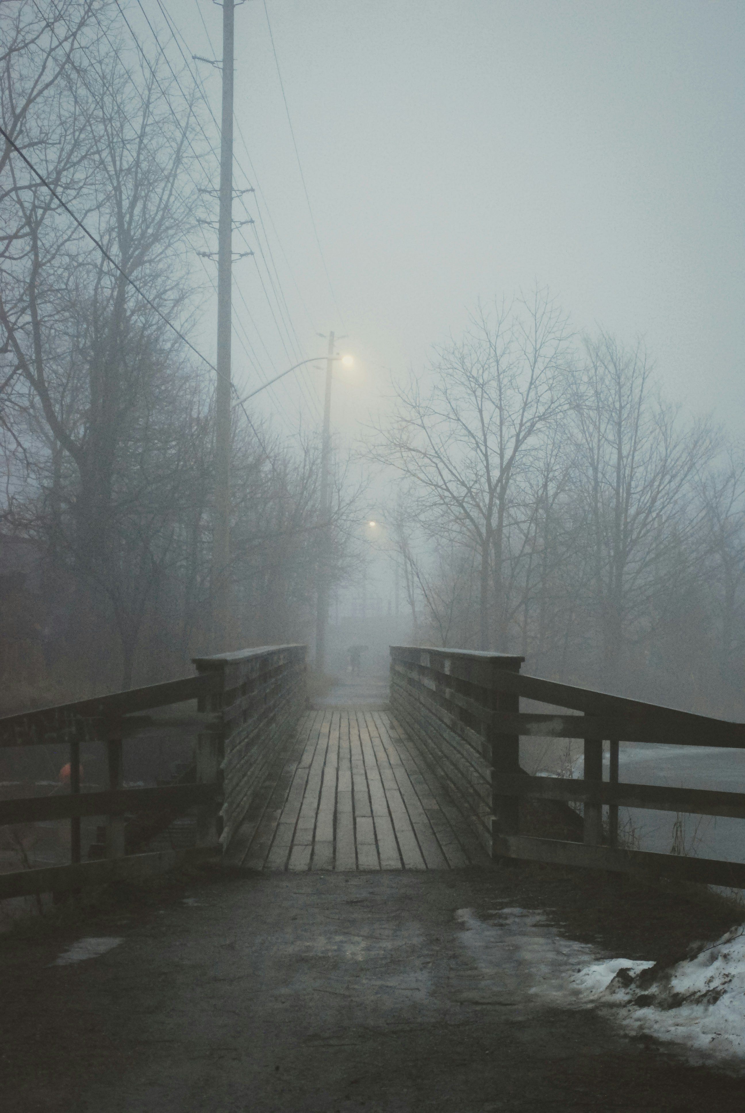 A foggy bridge with a street light in the distance photo – Free ...