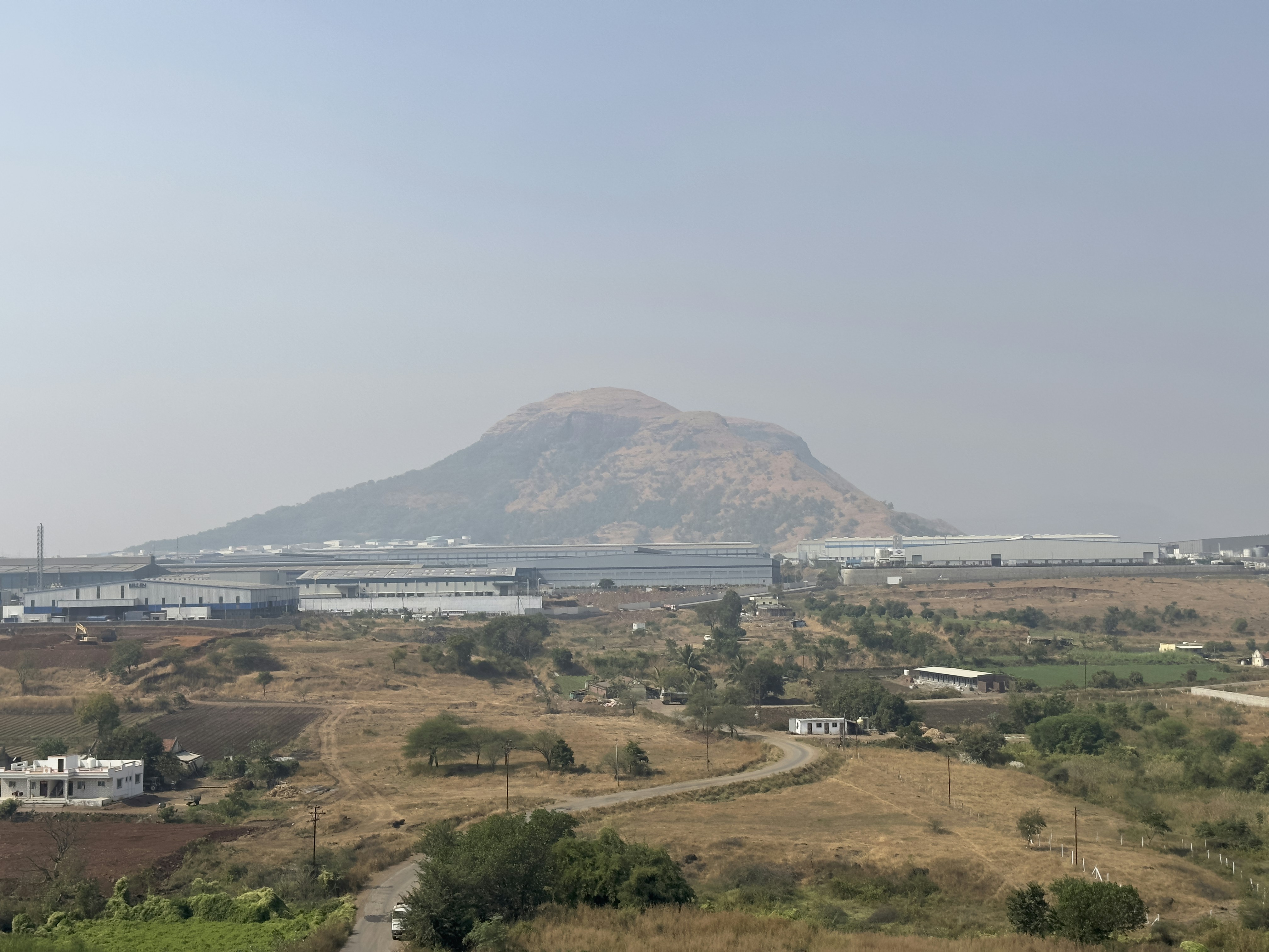 A view of a mountain with a road in the foreground photo – Free ...