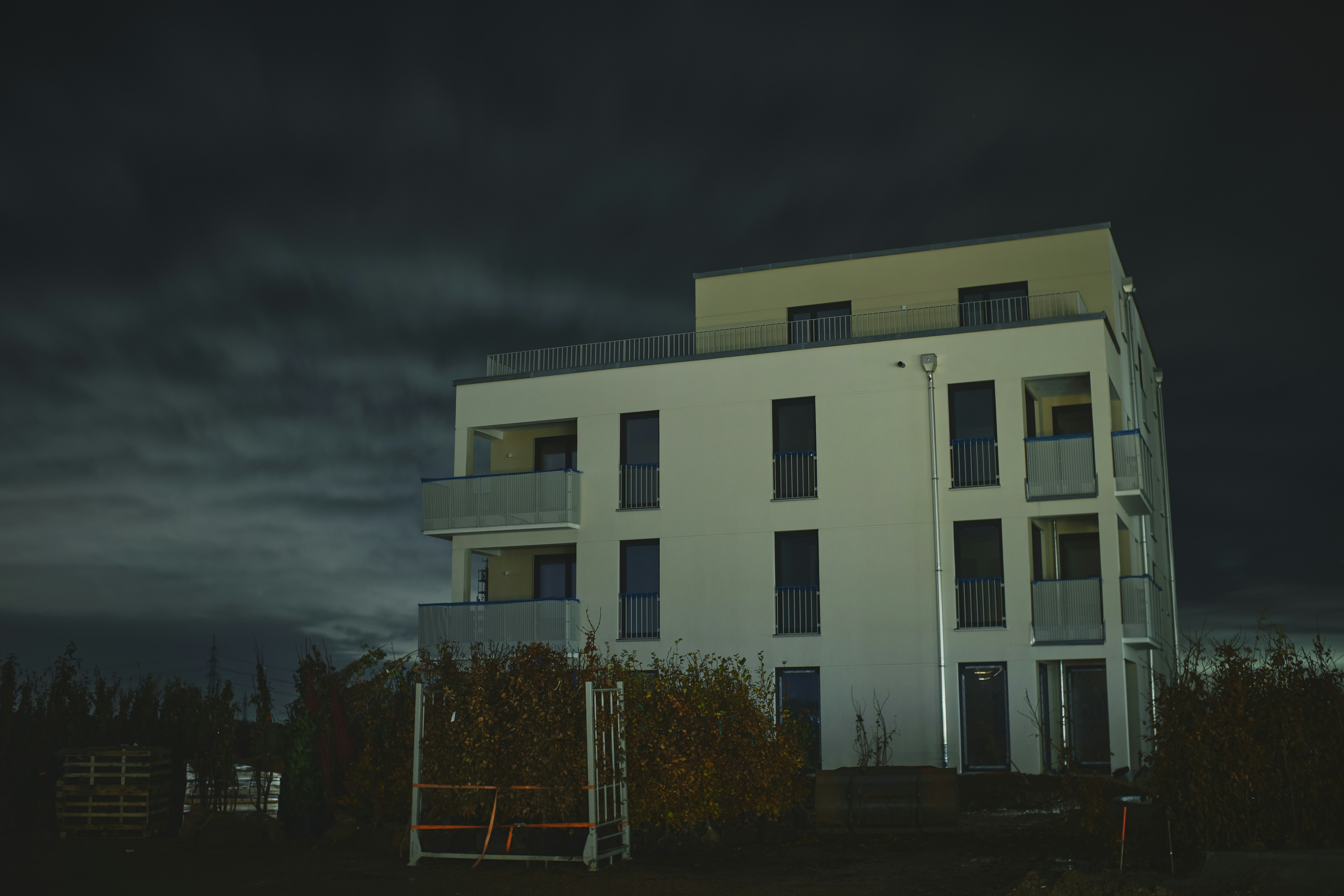 a large white building with balconies and a bench in front of it