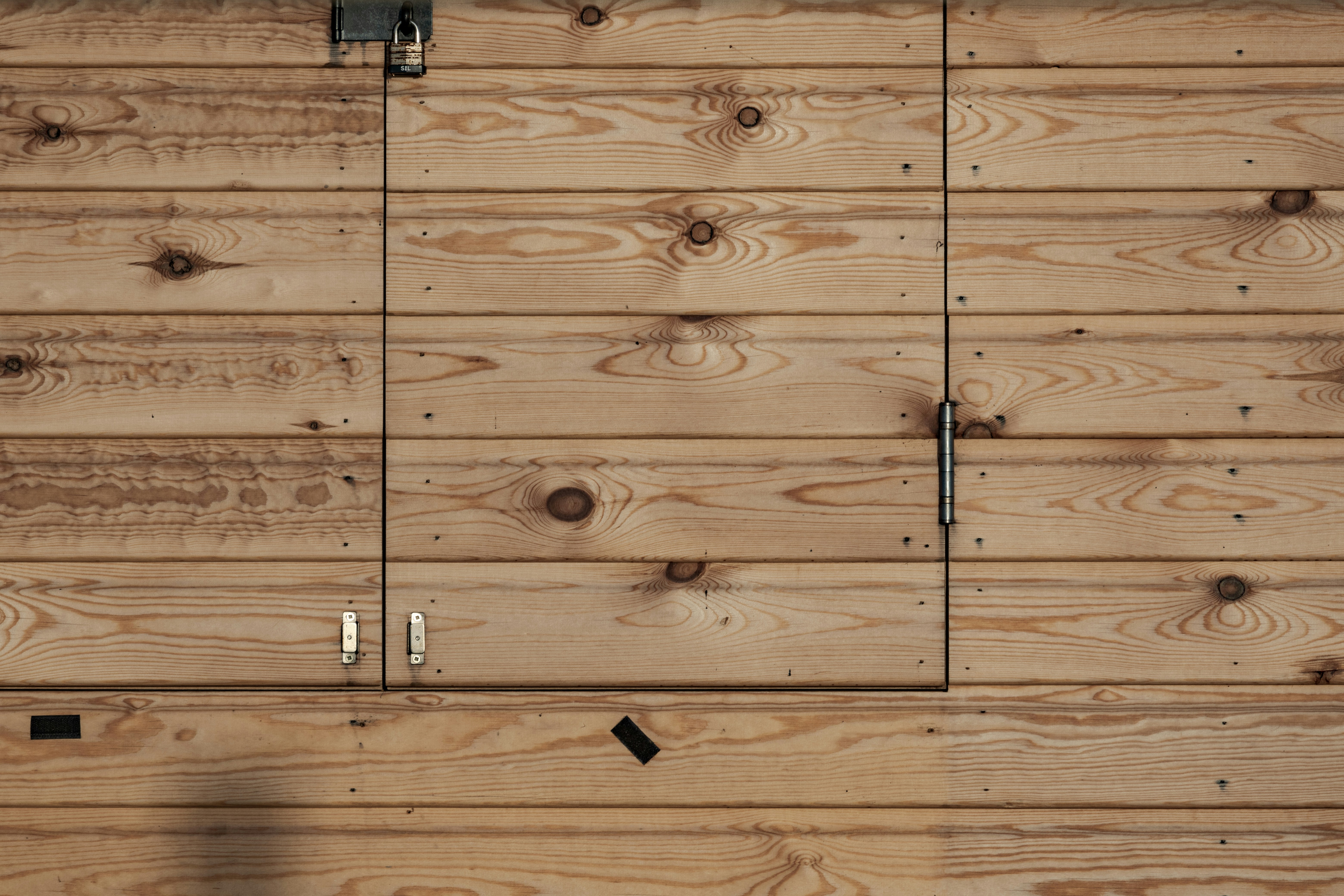 Hidden latch and timber rhythm on a cedar wall