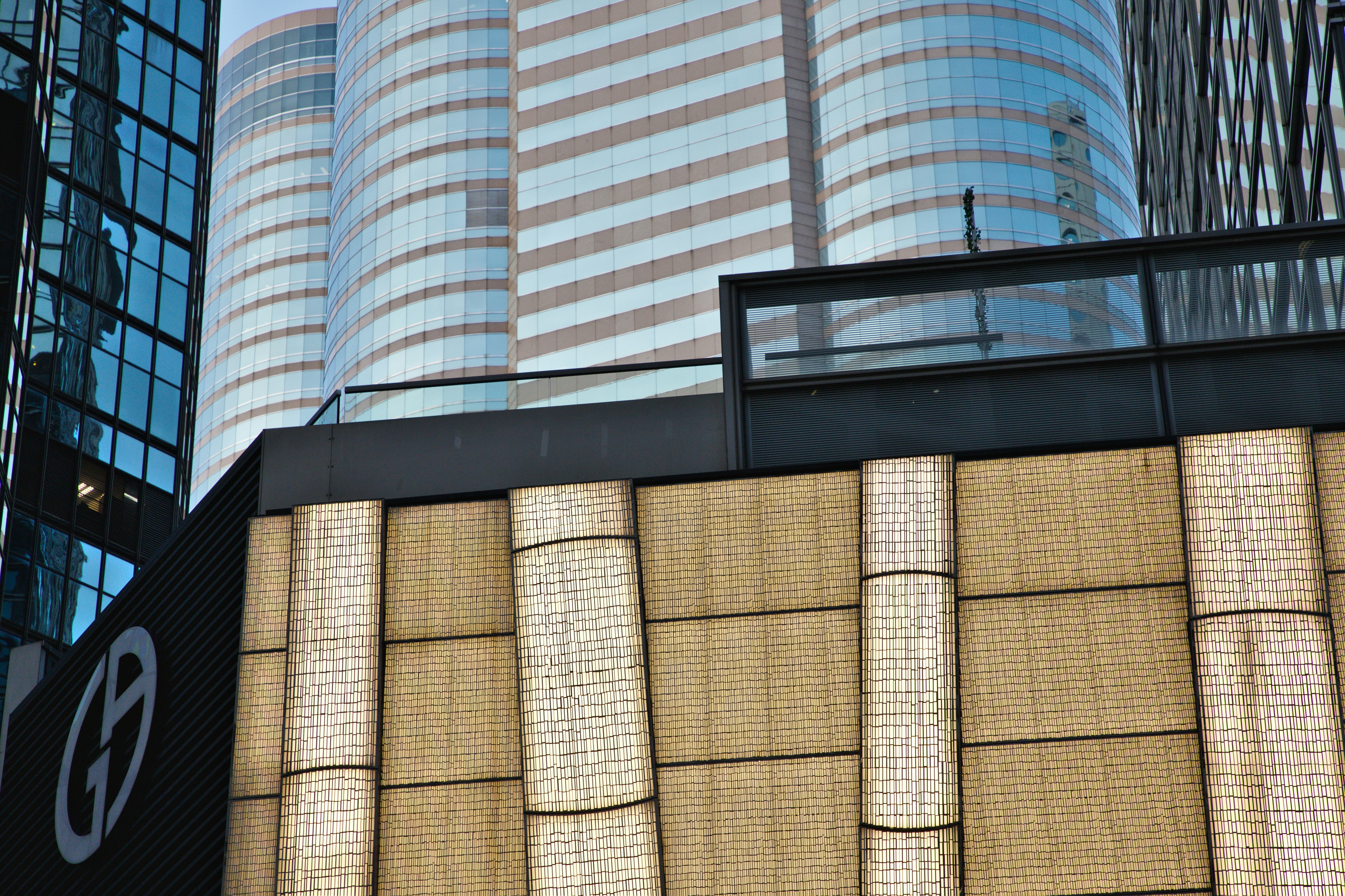 Modern architectural facades reflect light and structure in an urban setting, showcasing a blend of materials and design elements.