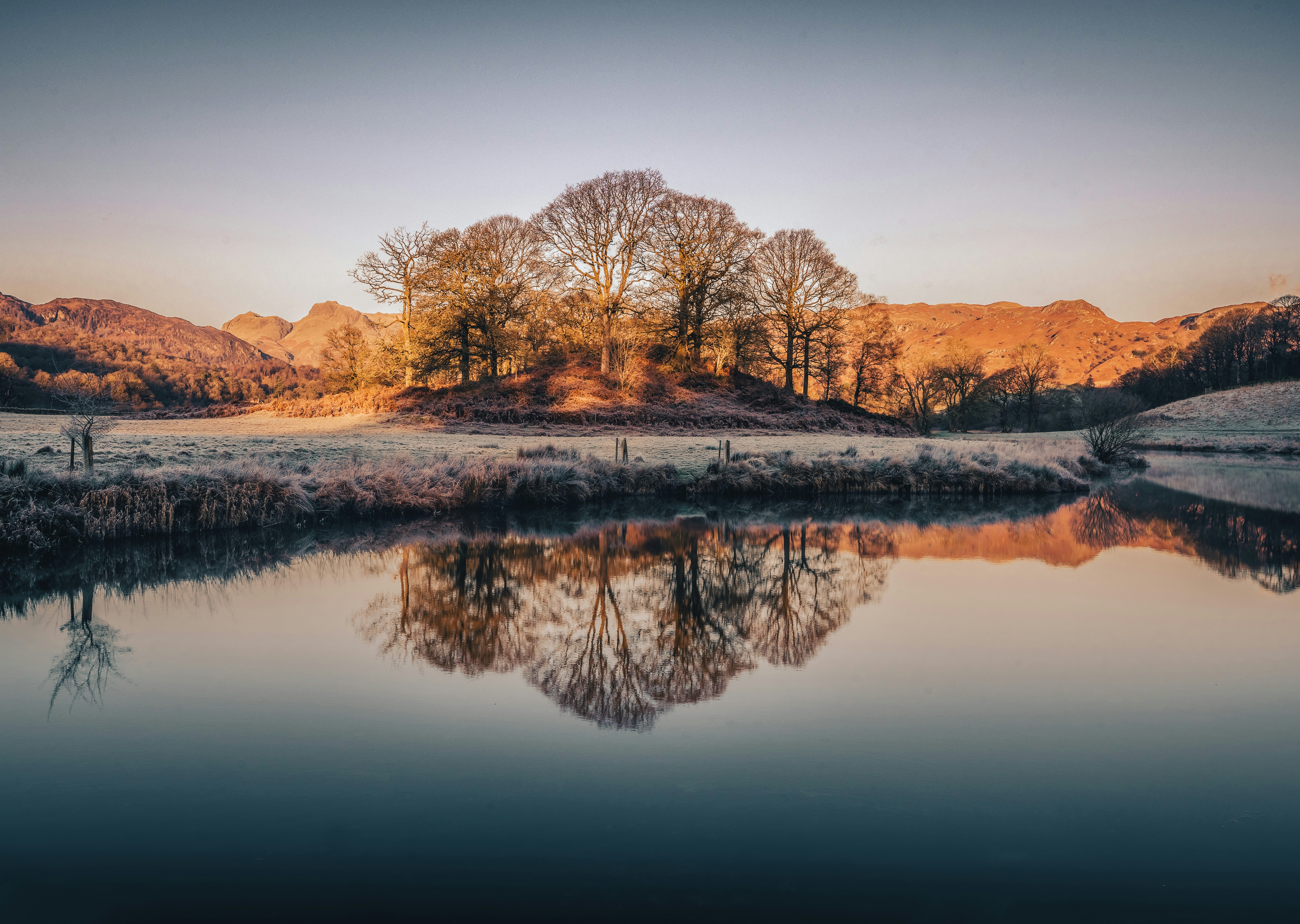A body of water surrounded by mountains and trees photo – Free ...