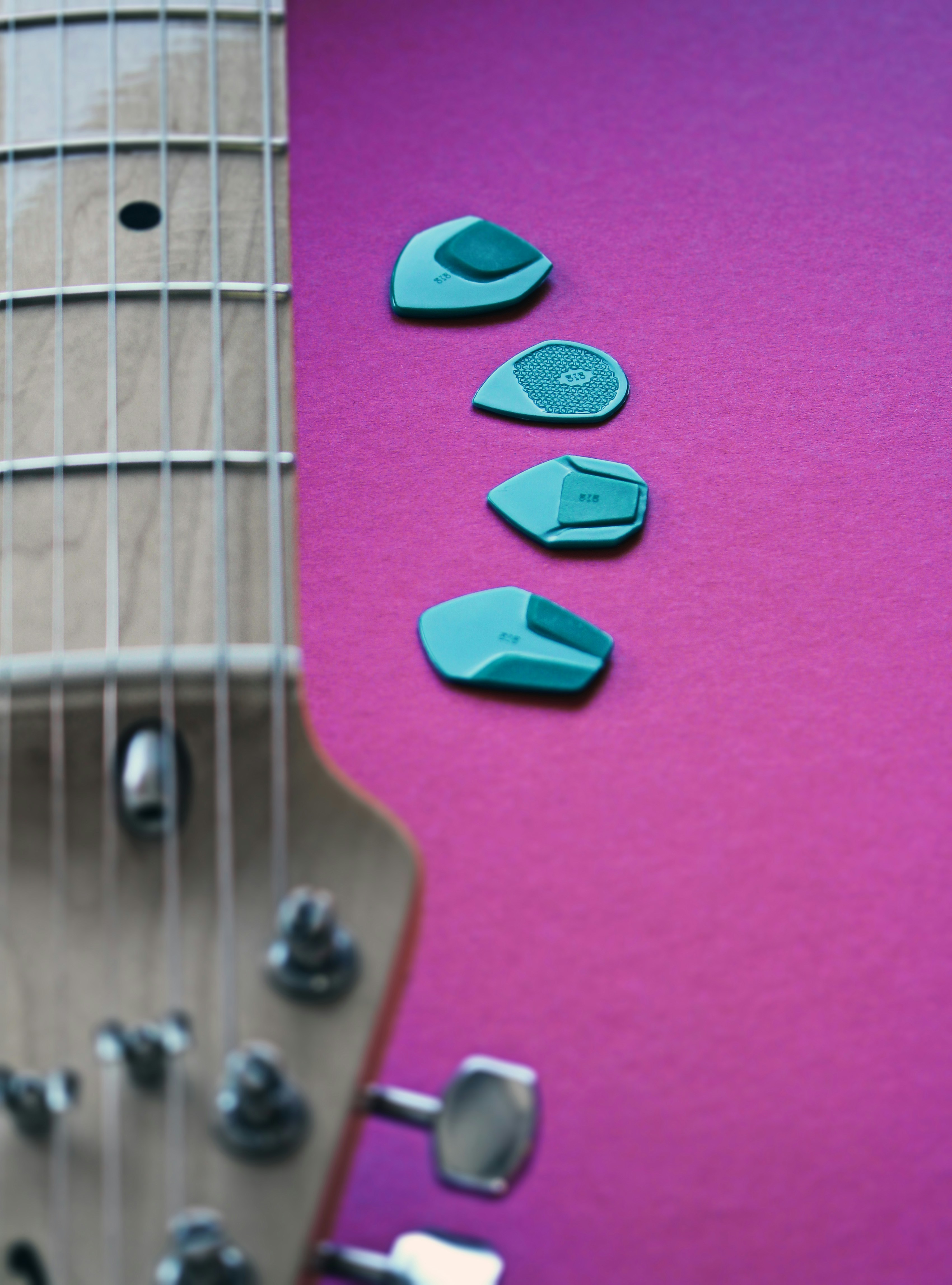 A close up of a guitar picker on a pink background photo – Free Guitar ...