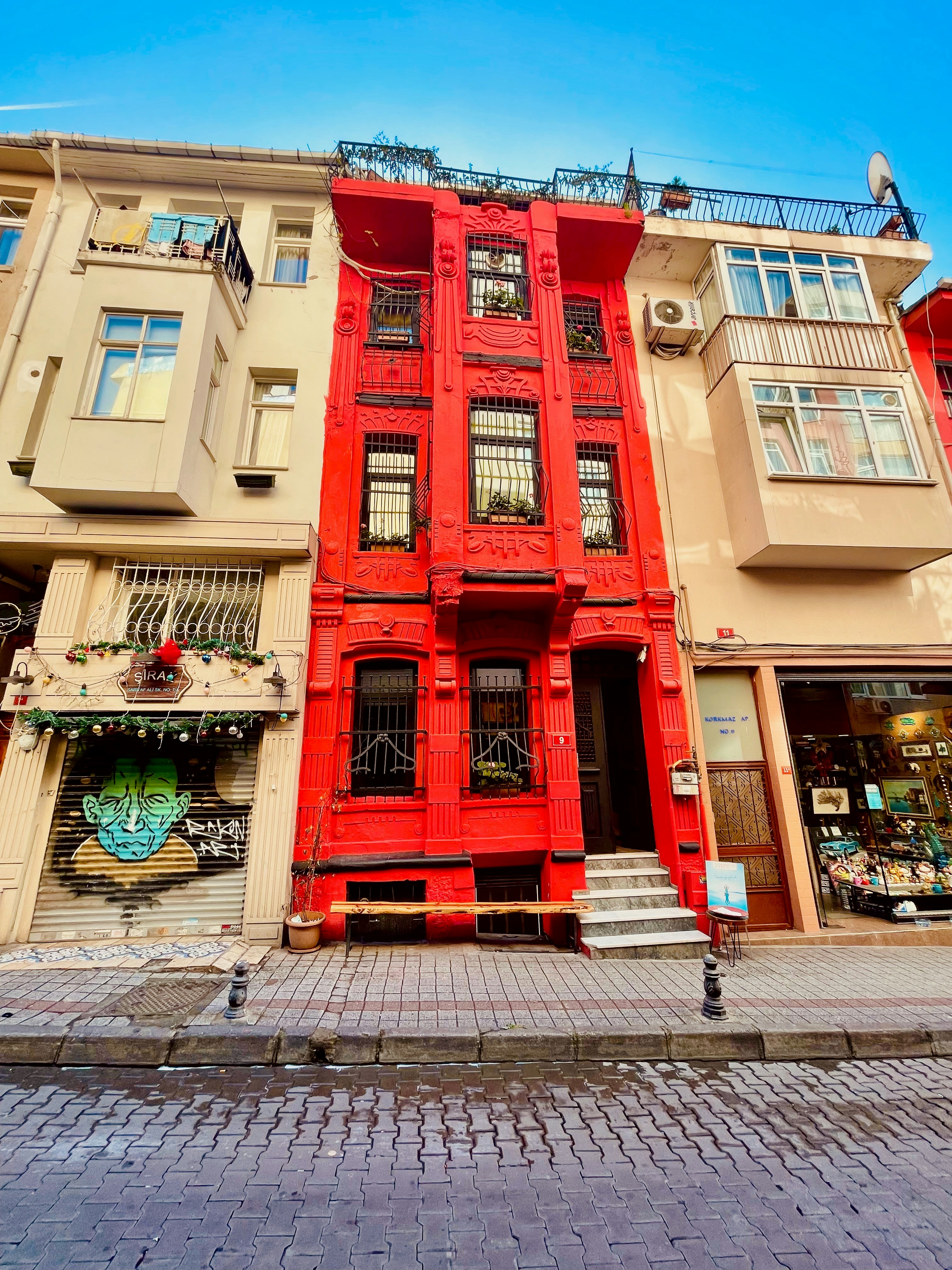 The Scarlet Facade: A Bold Centerpiece Among Quiet Beige Neighbors