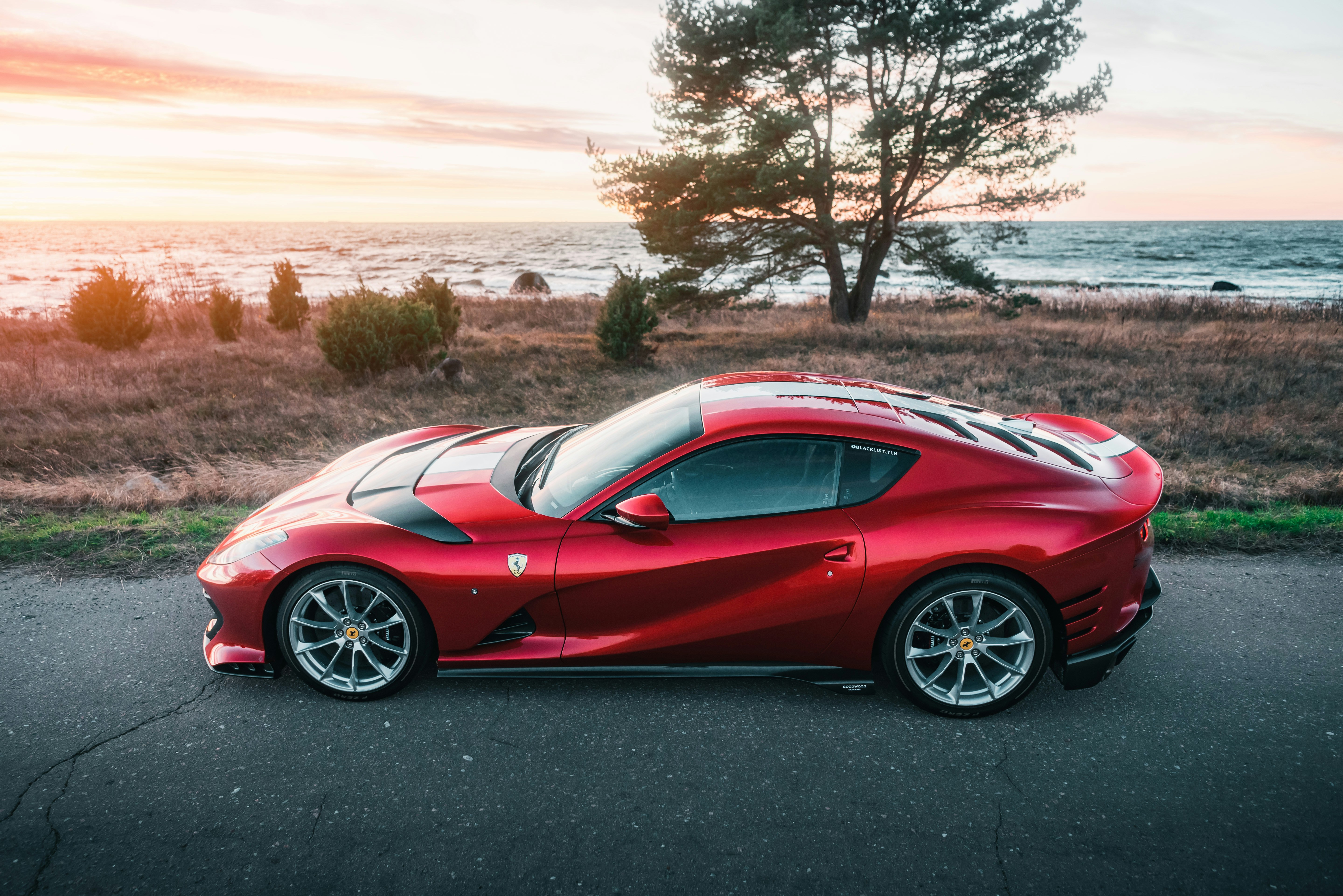 Un'auto sportiva rossa parcheggiata sul ciglio della strada foto ...