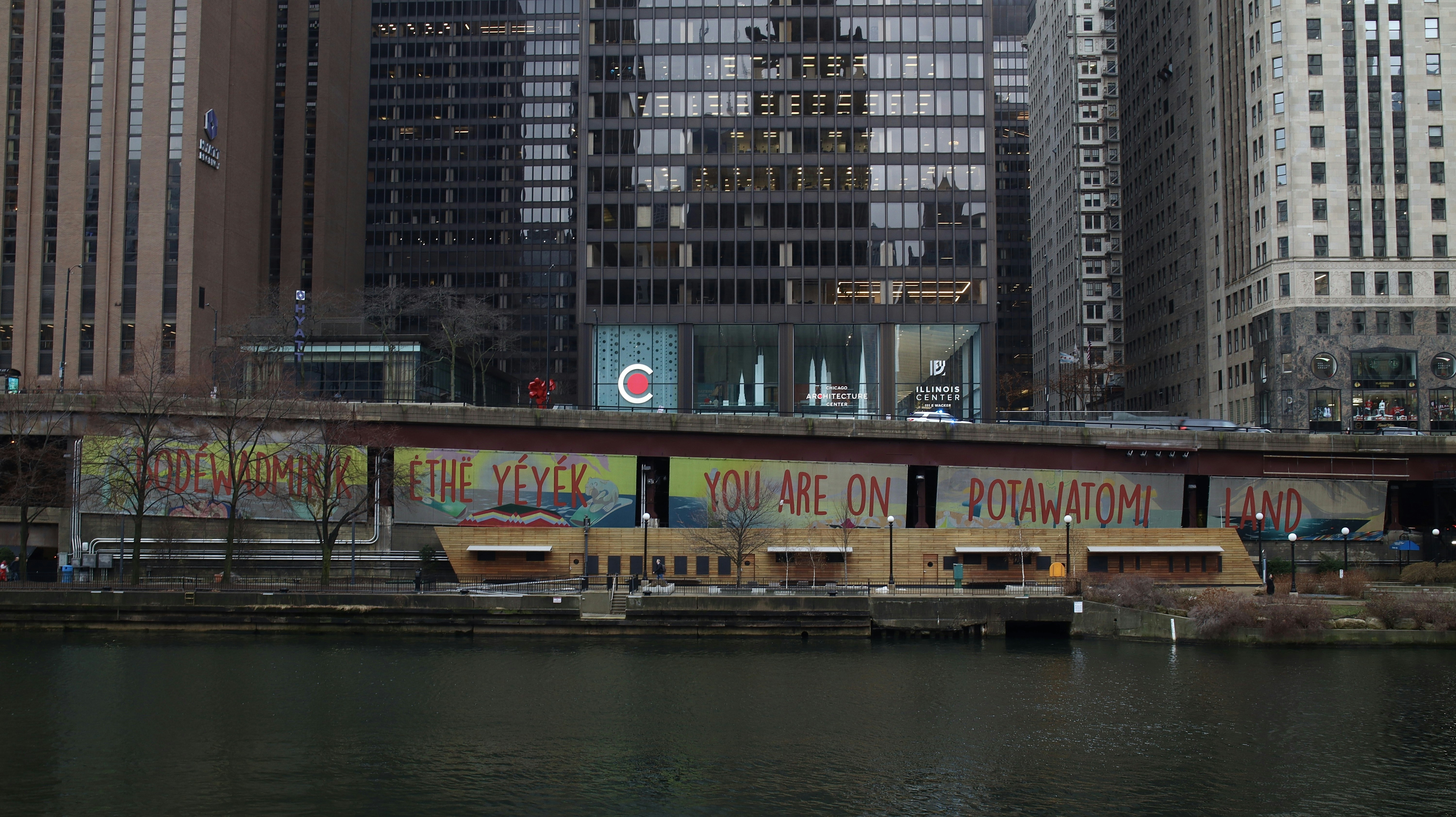 Graffitied Boatside Banner Under City Skyline