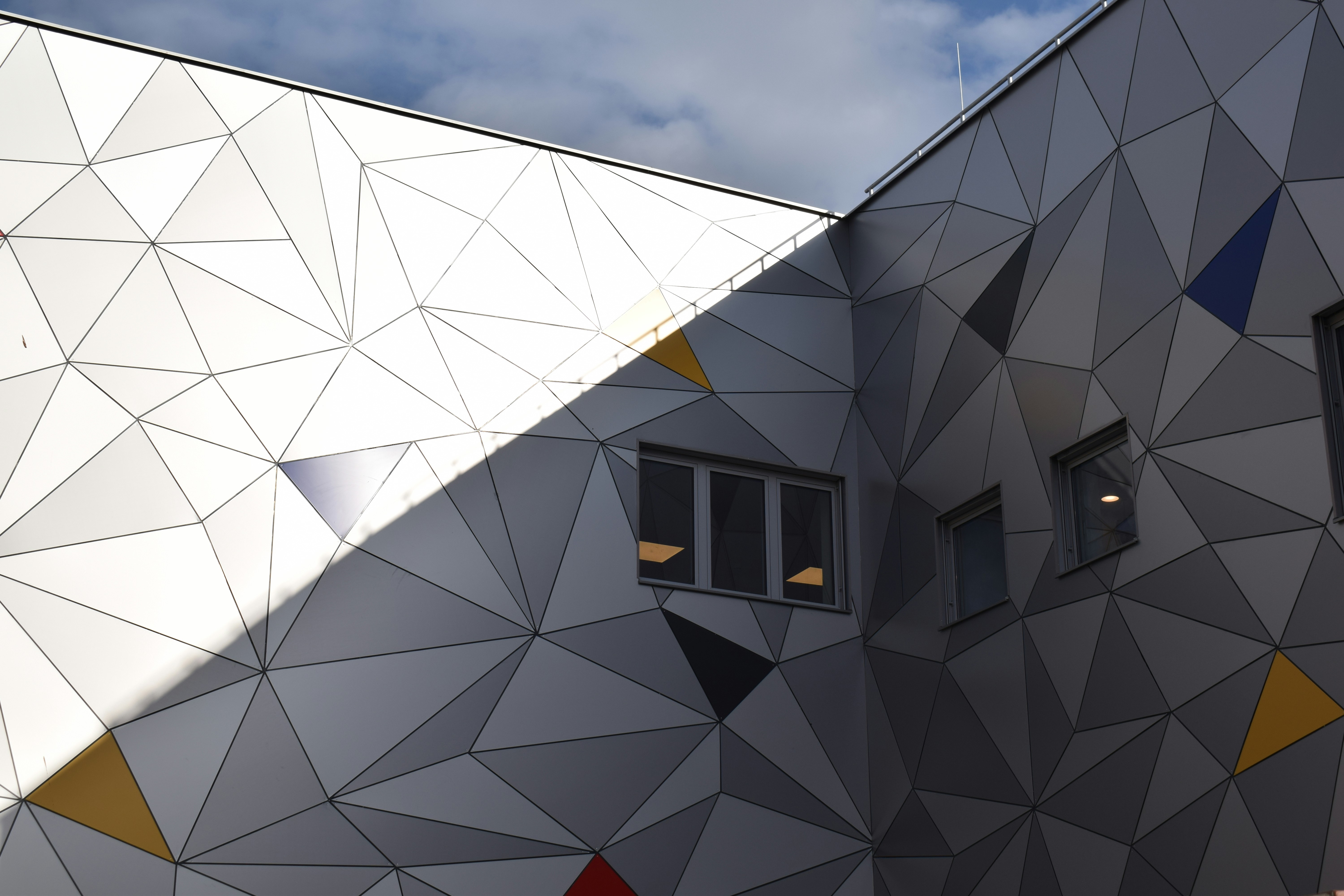 A building with a triangular design on the side of it photo – Free ...