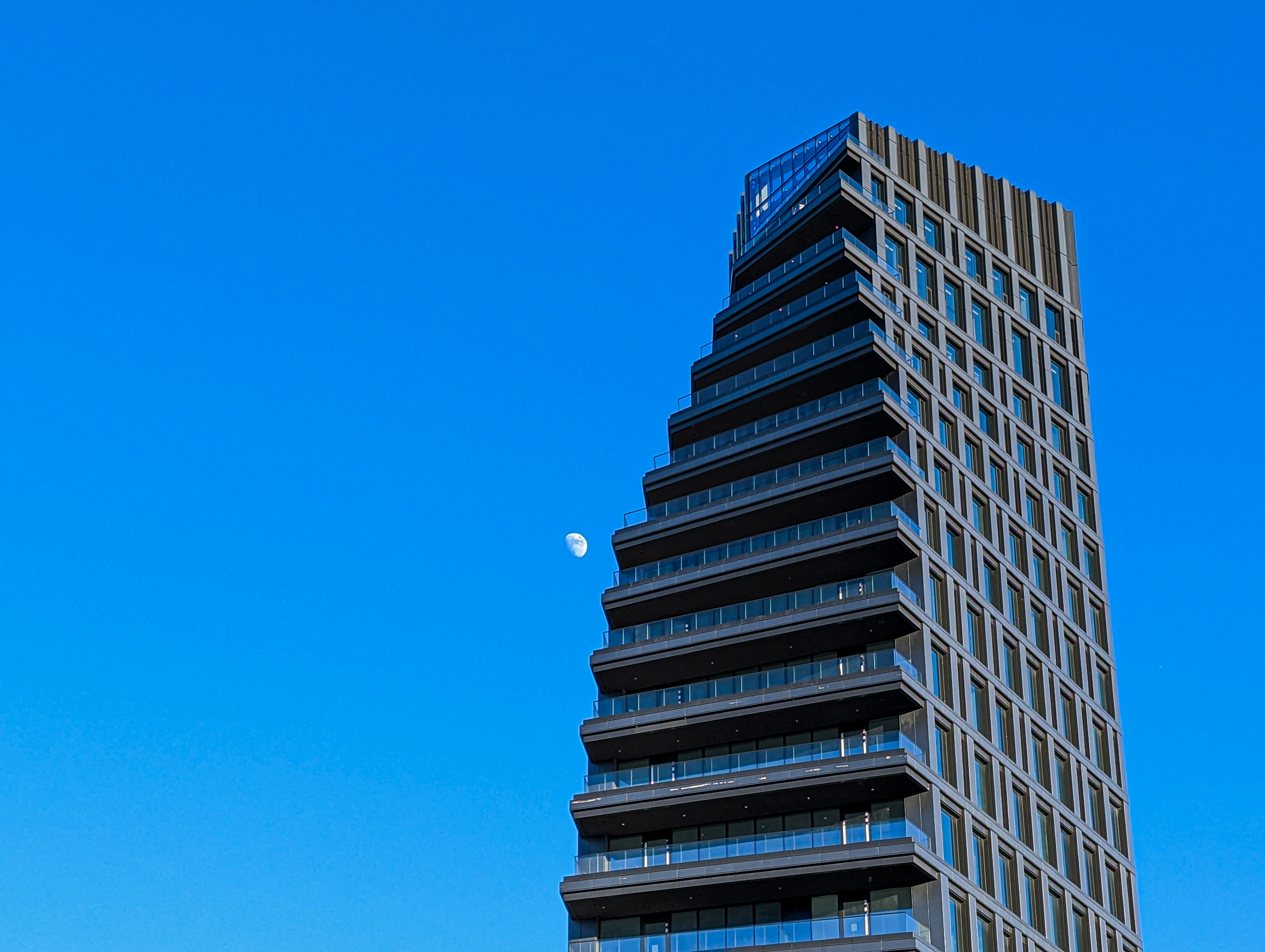 Stacked Skyward: a stepped skyscraper piercing a cobalt blue expanse