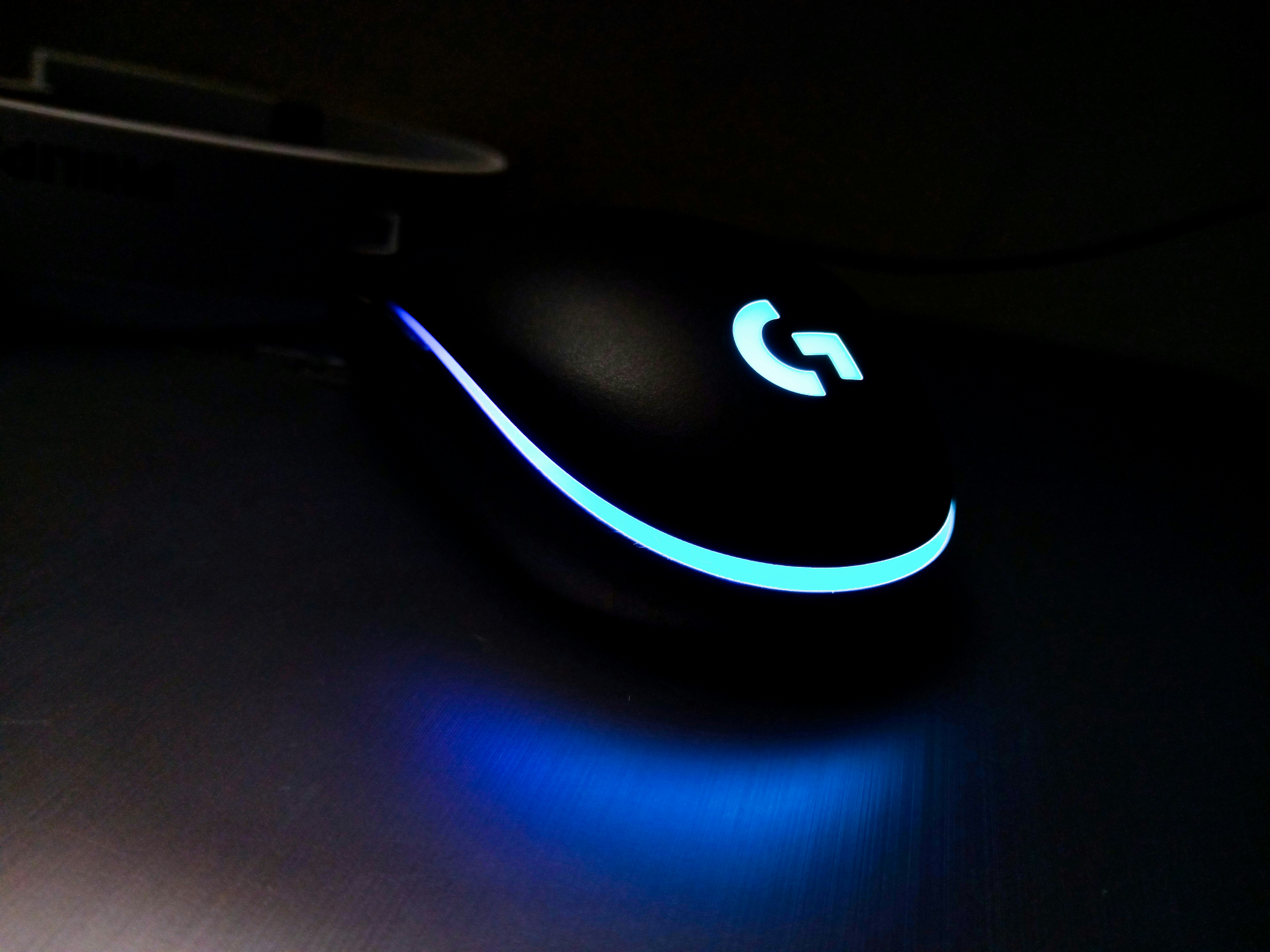 Sleek black gaming mouse with glowing blue LED accents on a dark surface.