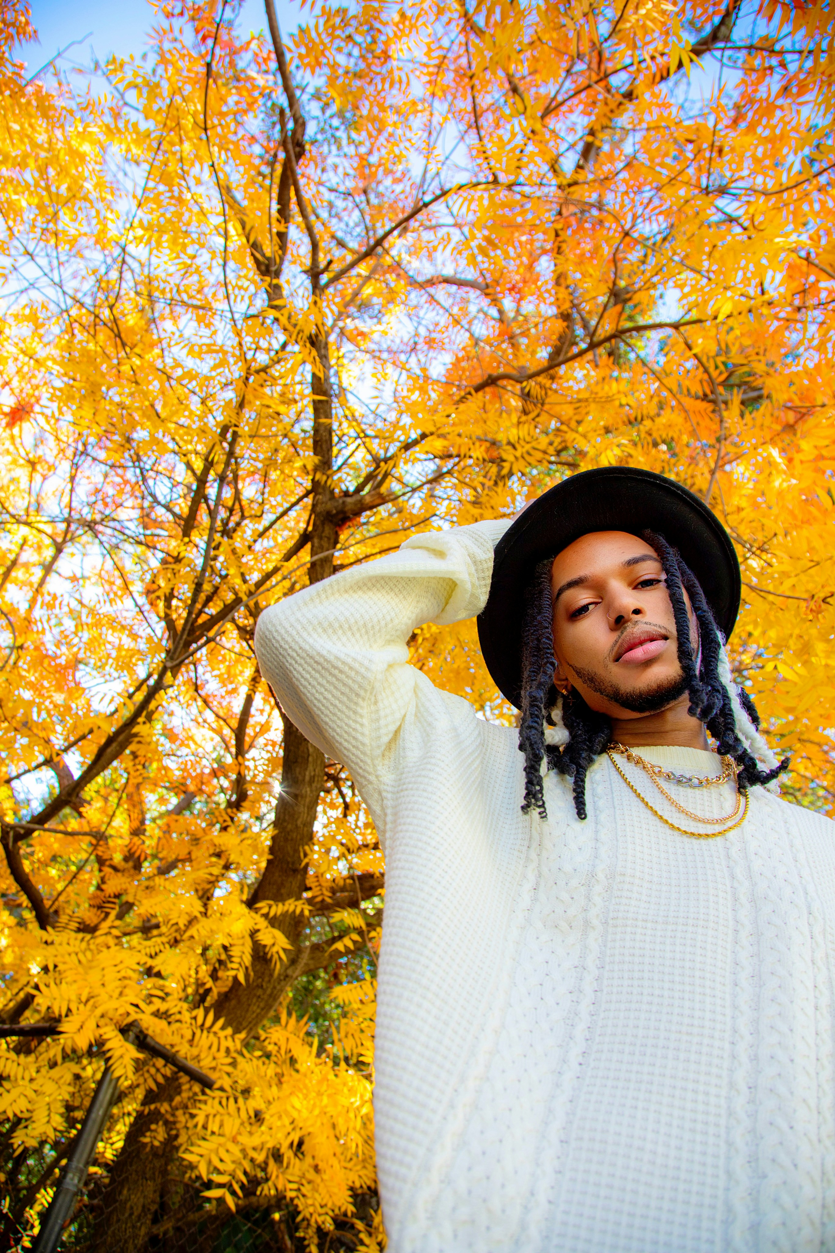 A man with dreadlocks standing in front of a tree photo – Free Portrait ...