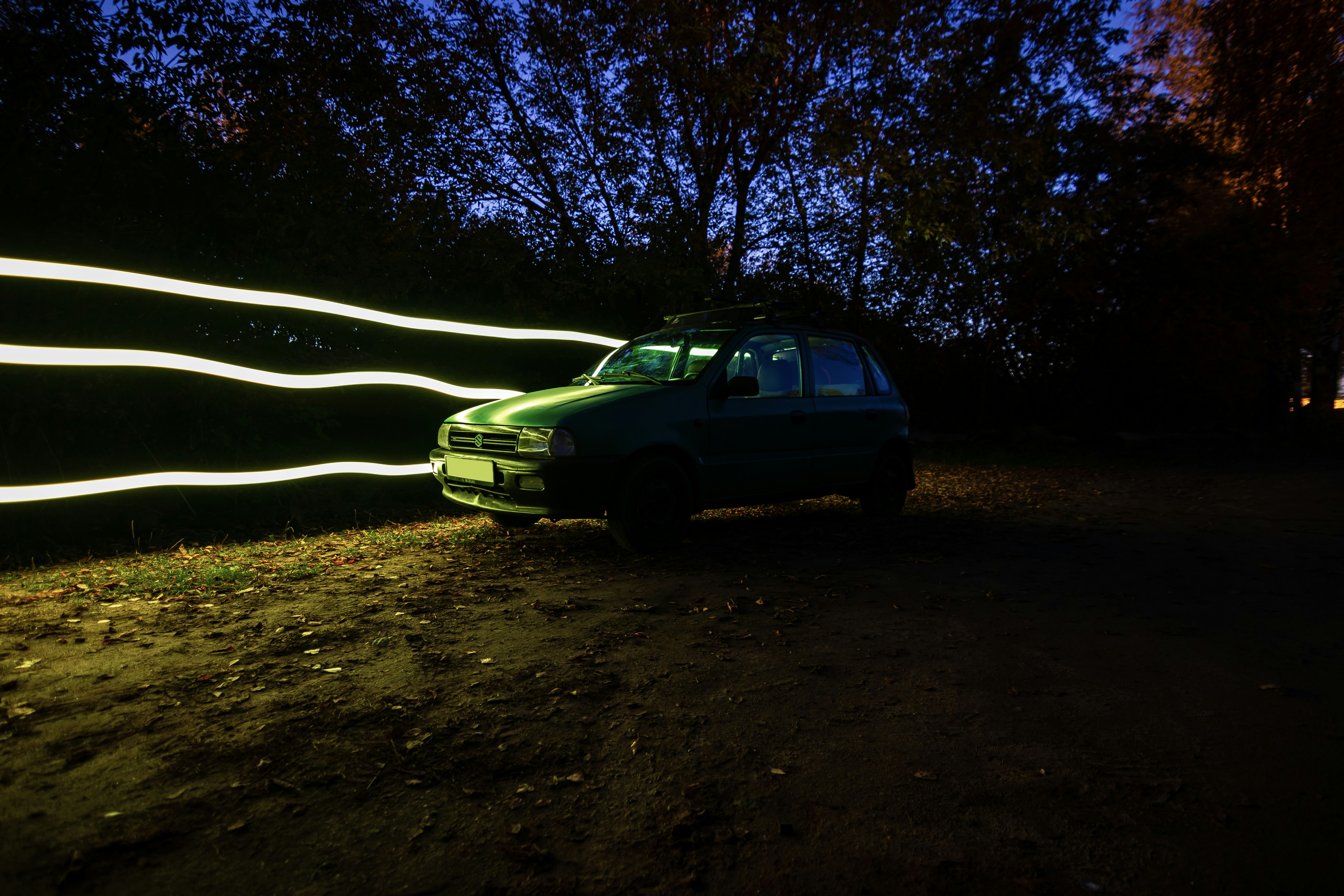 a green car parked on the side of a road