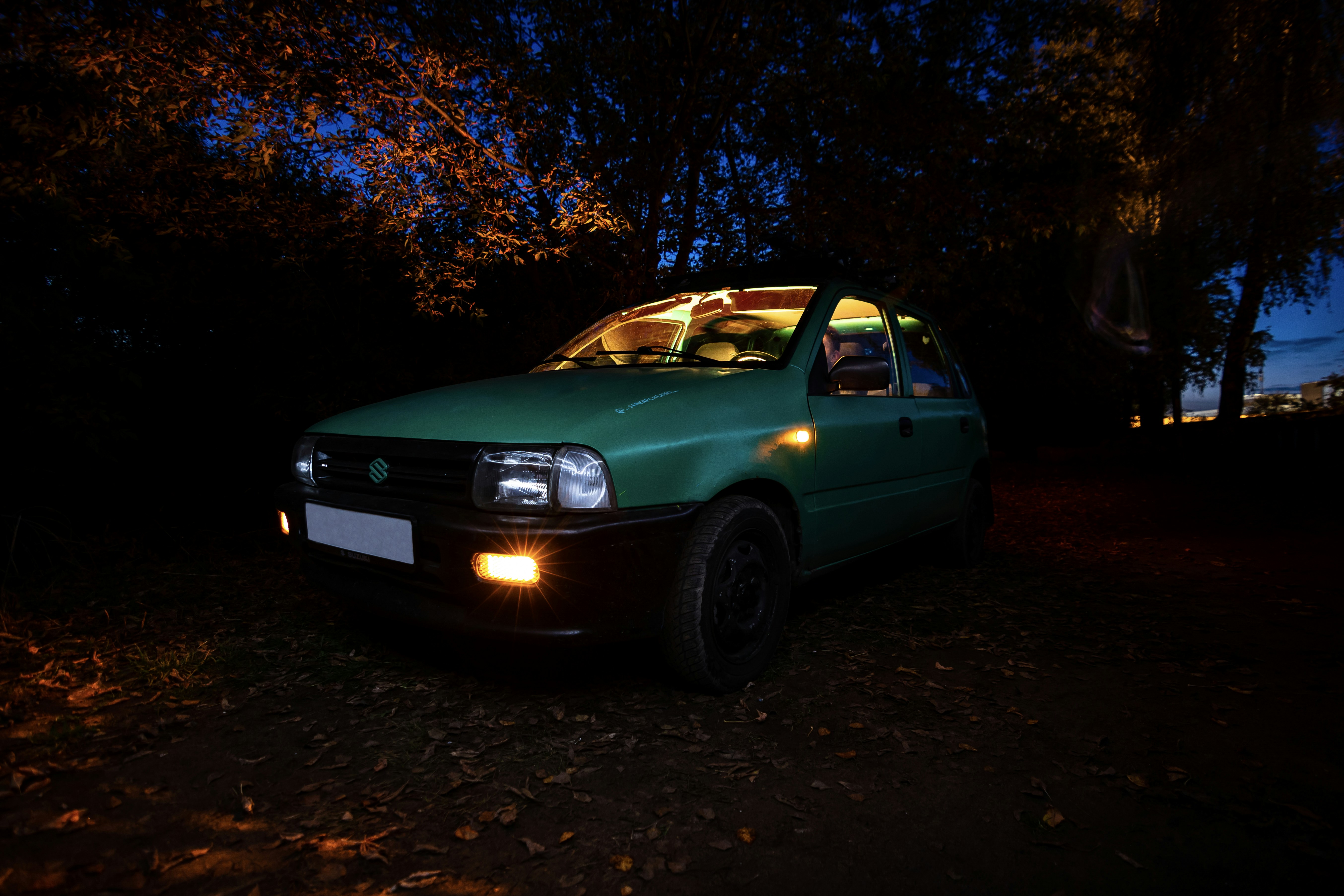 Moonlit Teal Hatchback in a Forest Clearing