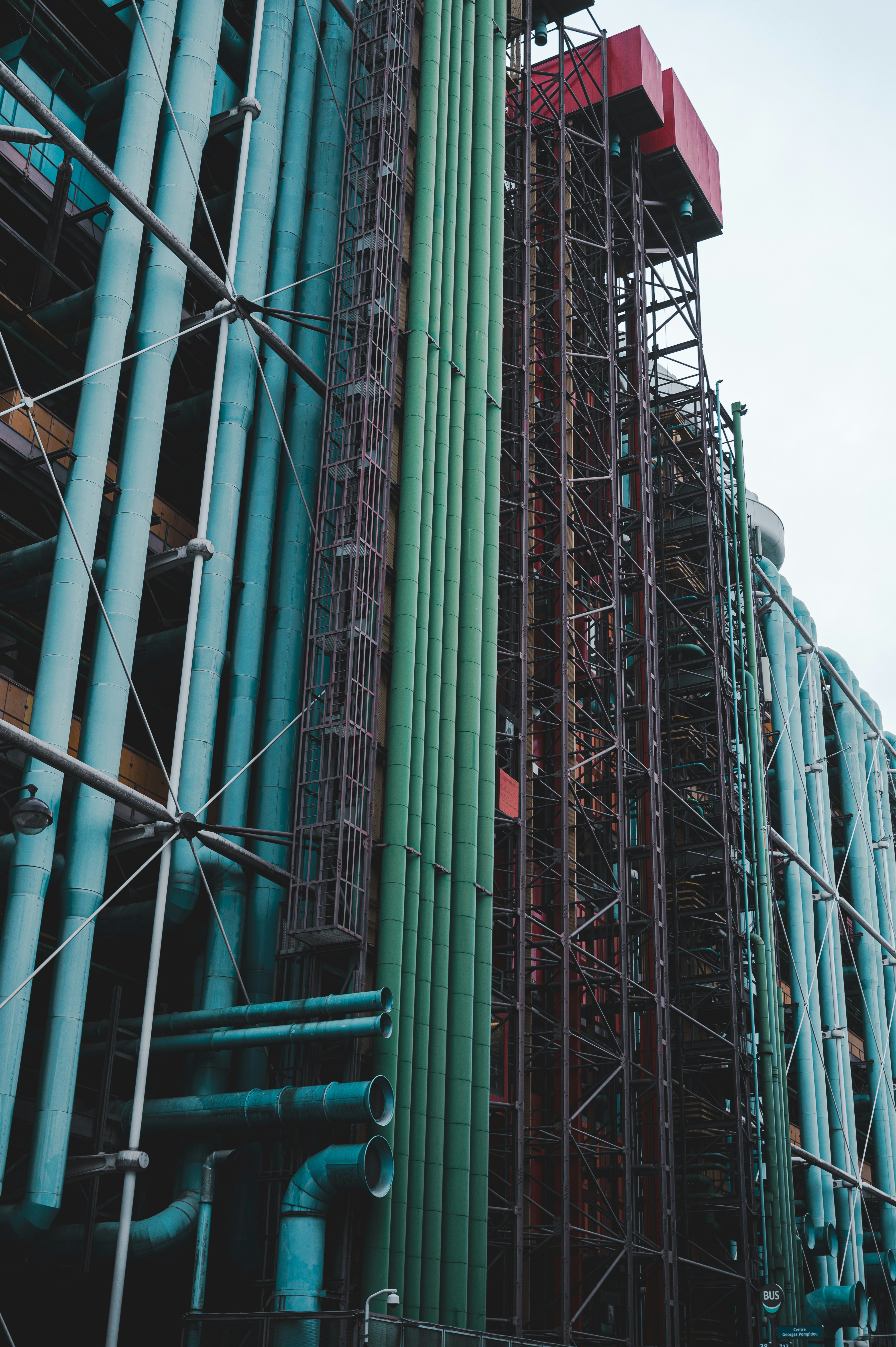 A large green pipe next to a tall building photo – Free Paris Image on ...