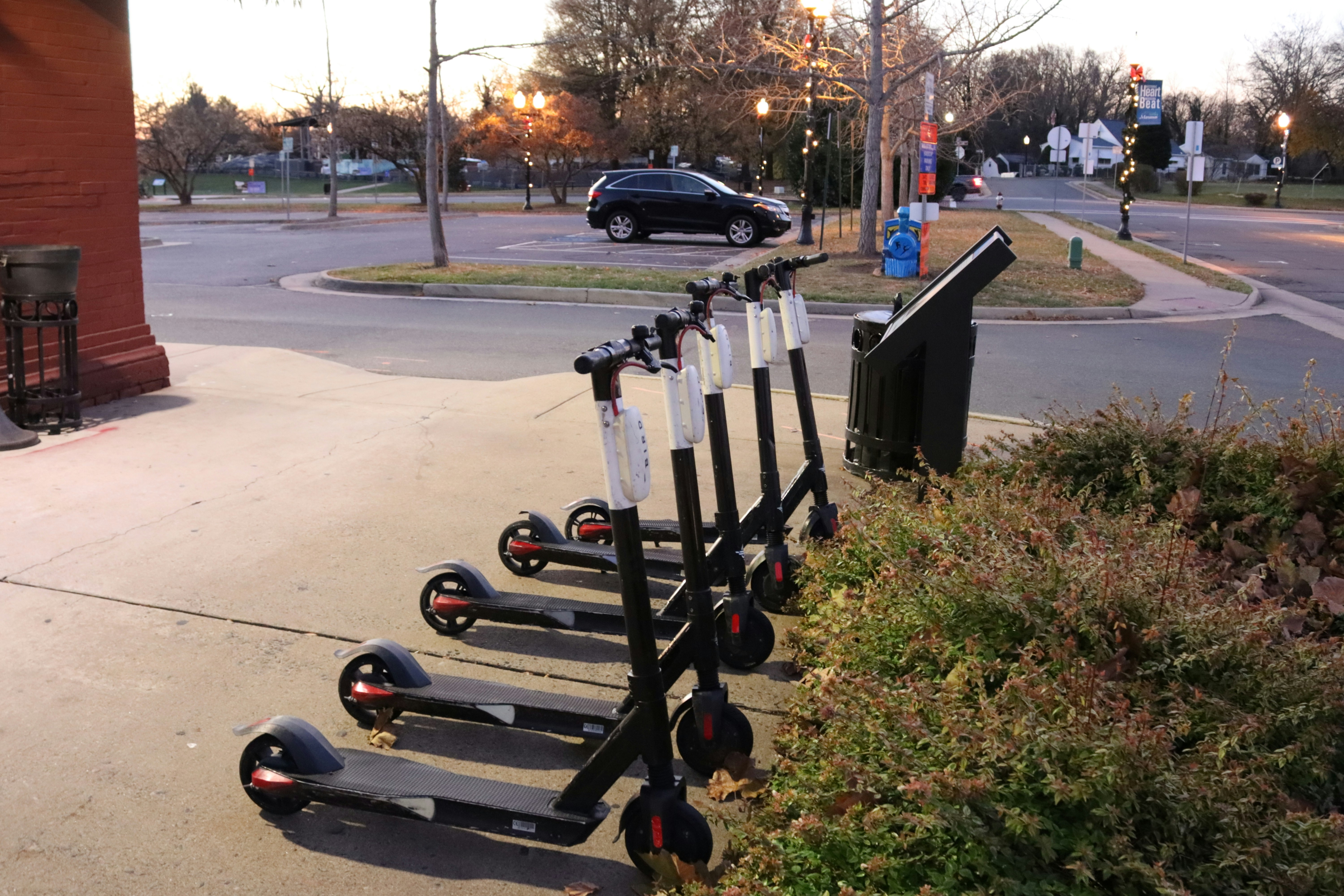 A row of scooters parked on the side of a road photo – Free Scooter ...