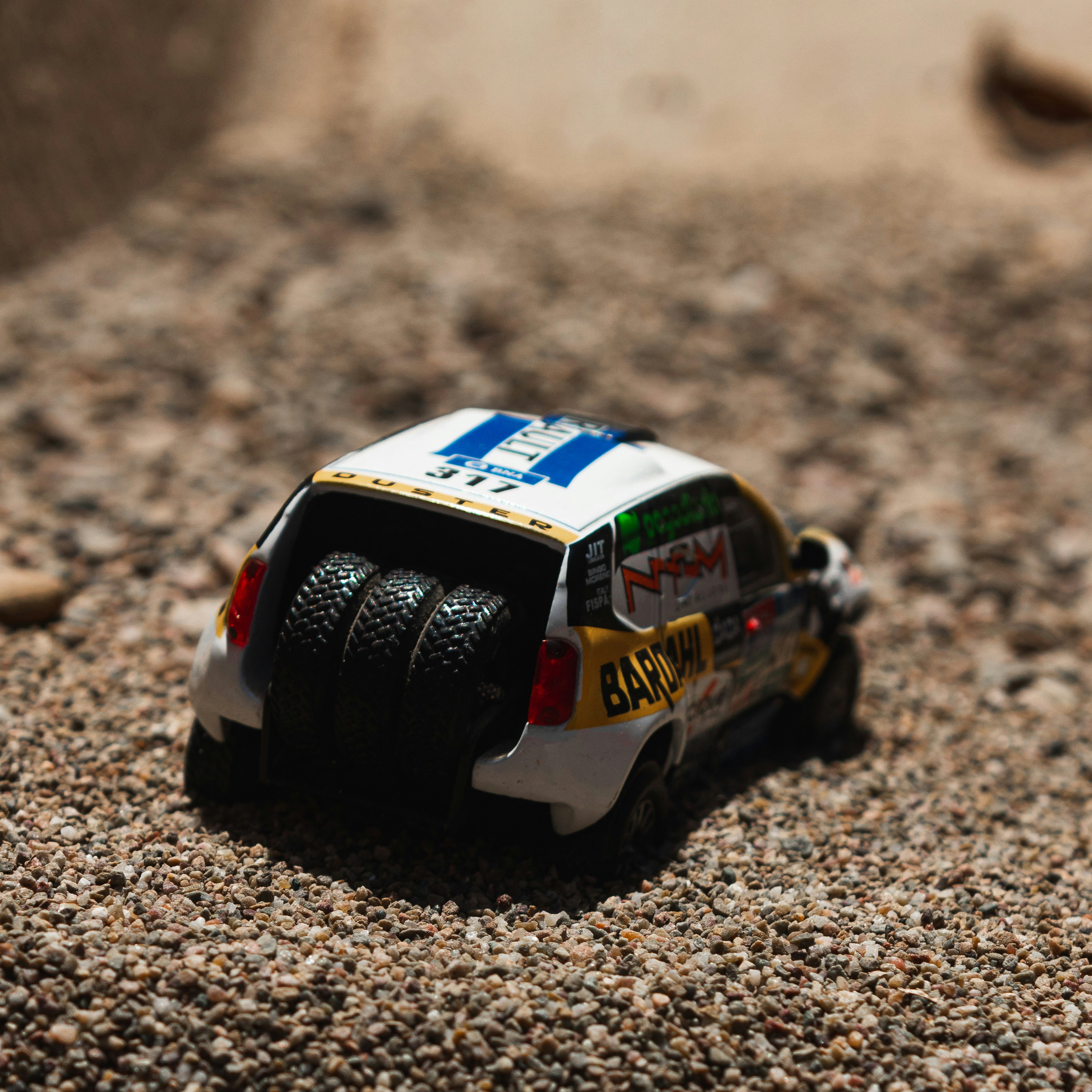 Dusty Rally Toy on Pebble Ground