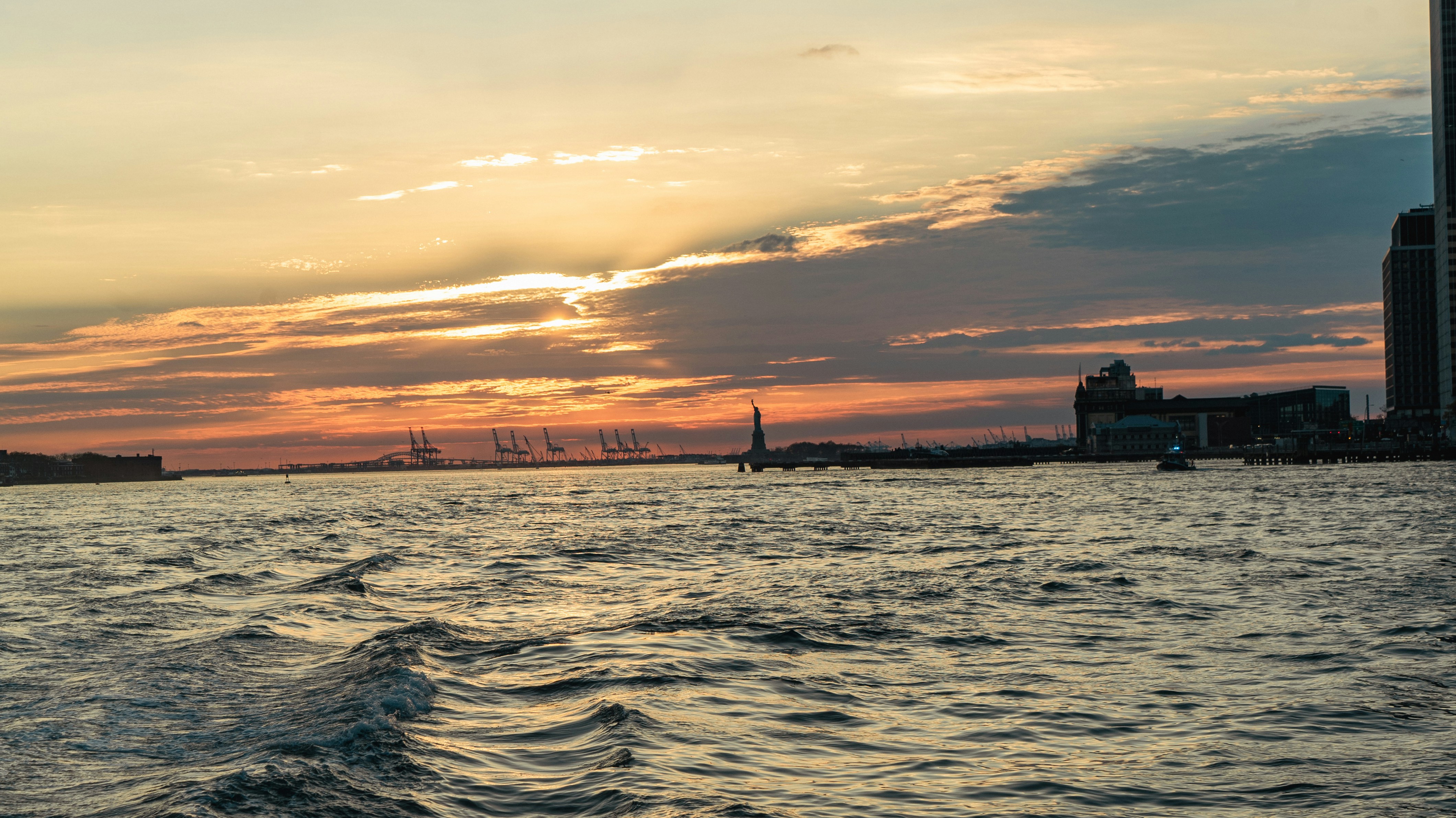Sunset on the River: City Silhouette Beyond Gentle Waves