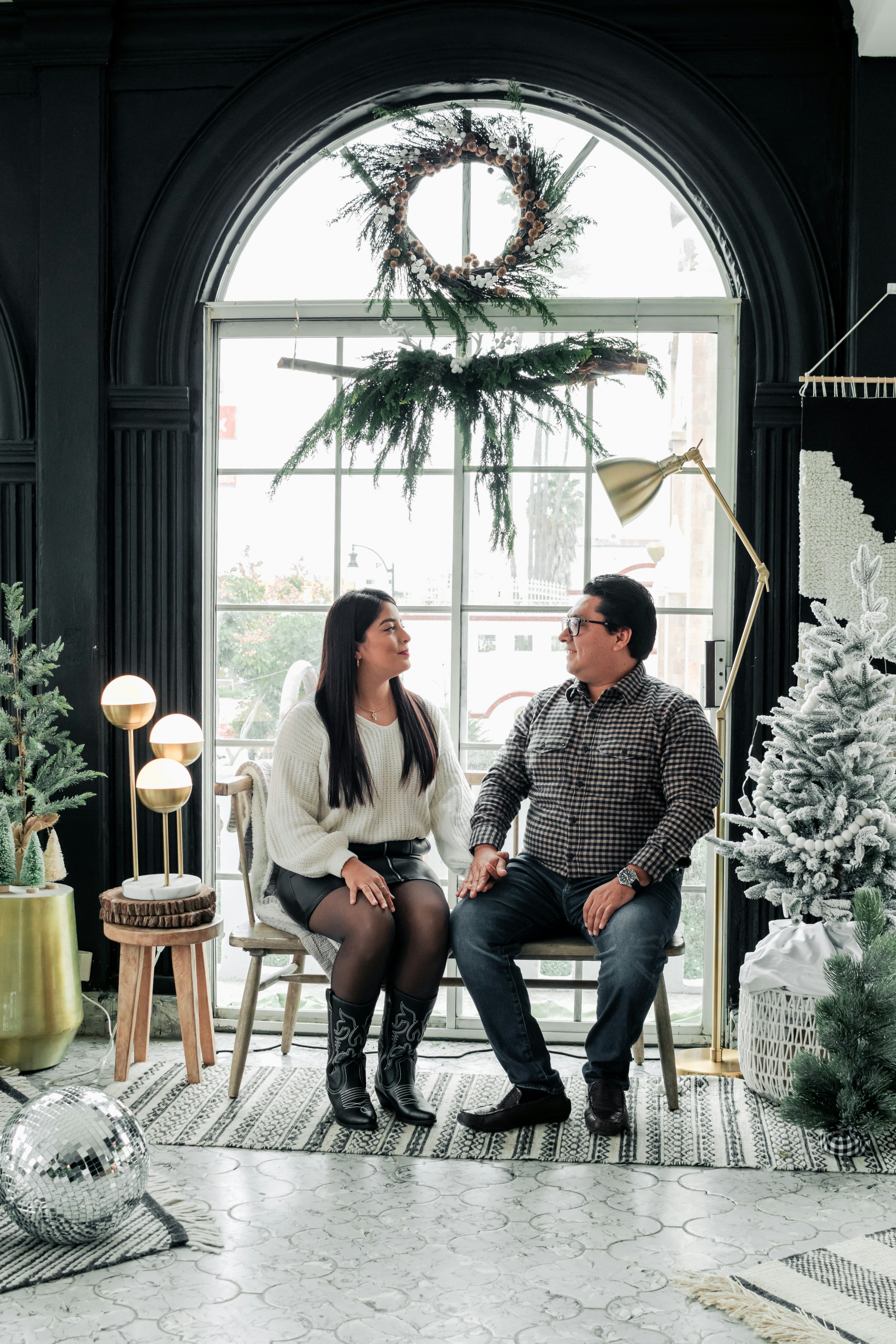 Windowed Warmth: An Intimate Holiday Moment Beside Wreaths
