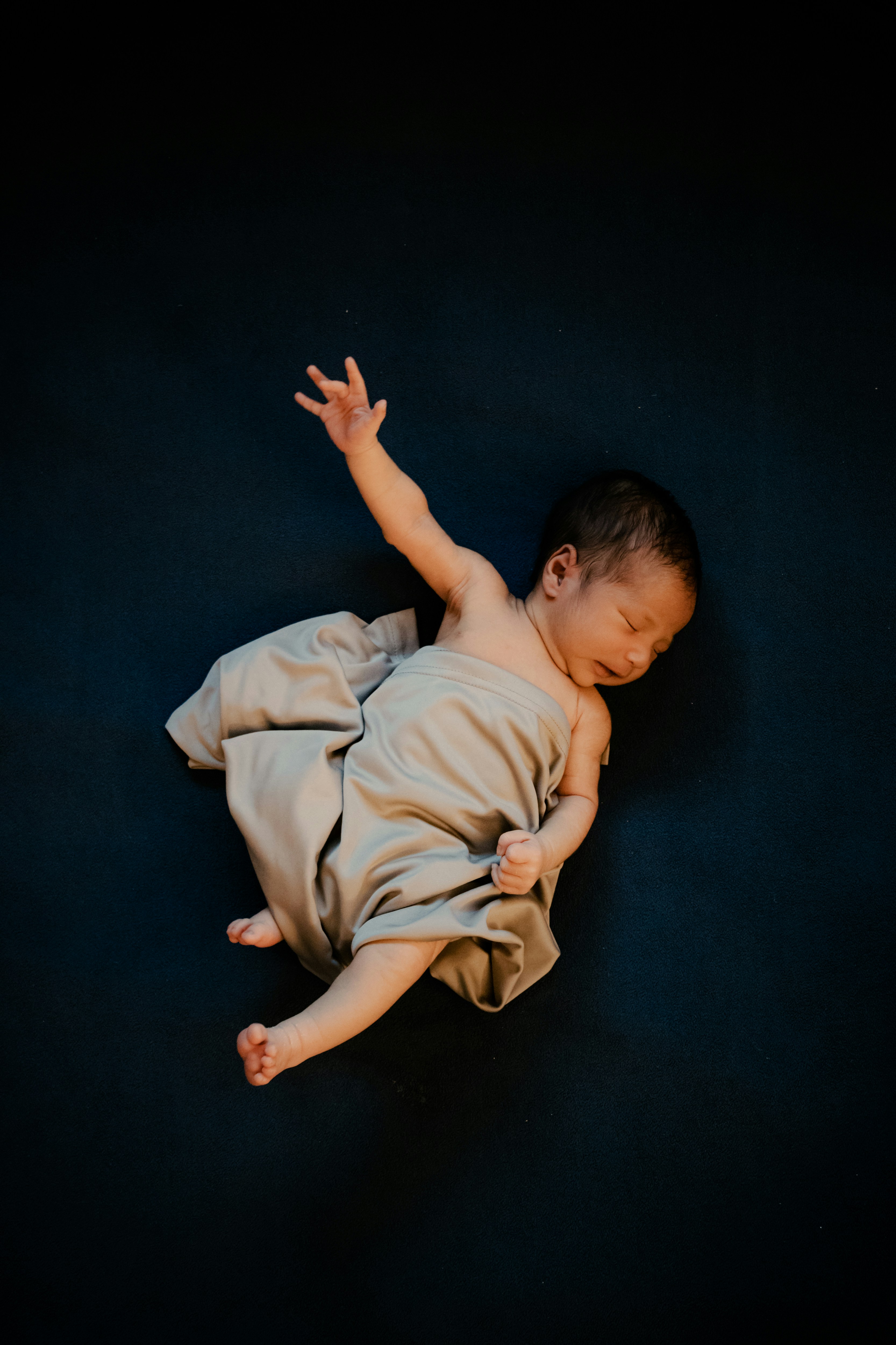 a baby is laying down on a black surface