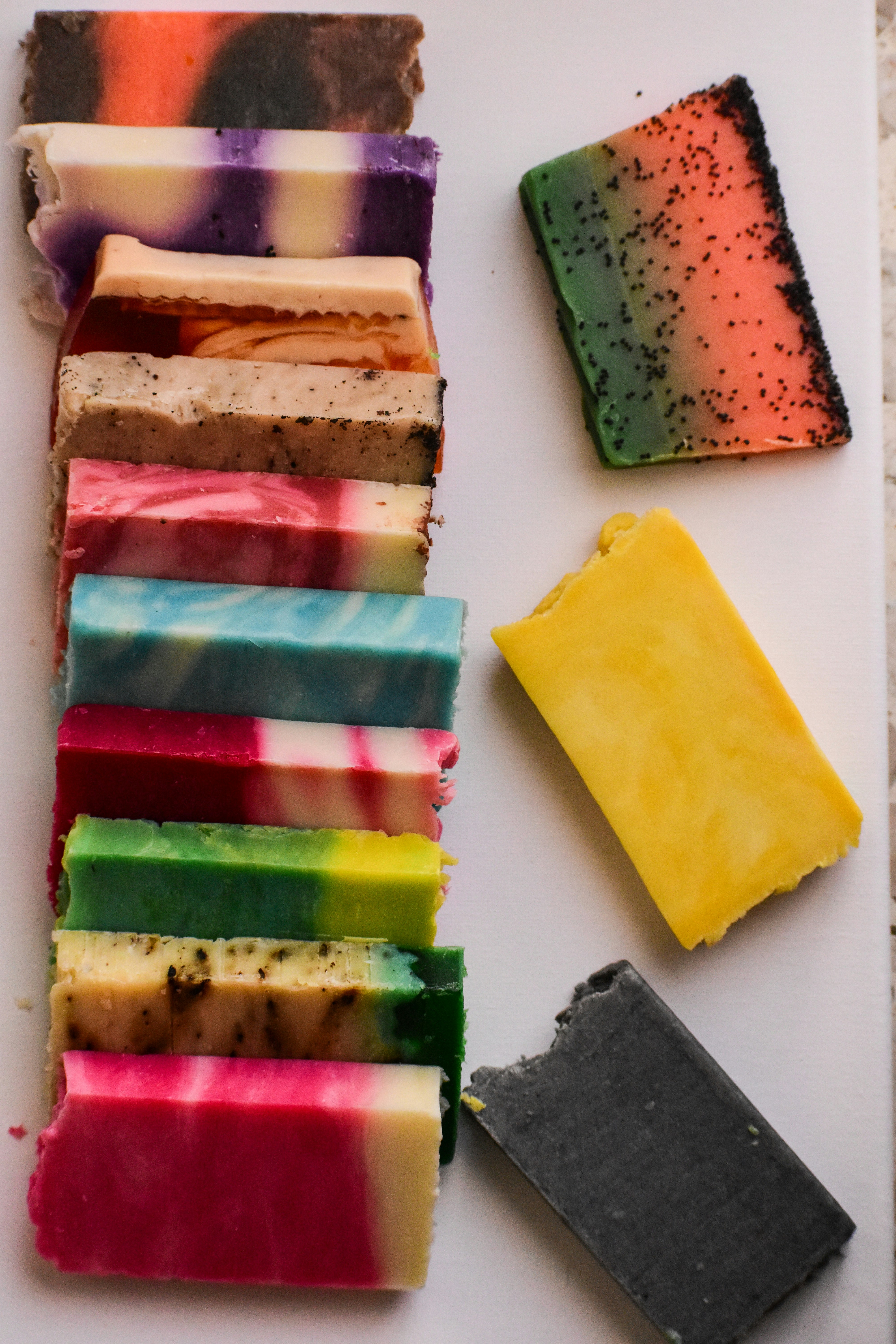 Vibrantly colored artisan soap bars arranged in a visually appealing manner, showcasing a variety of textures and patterns.